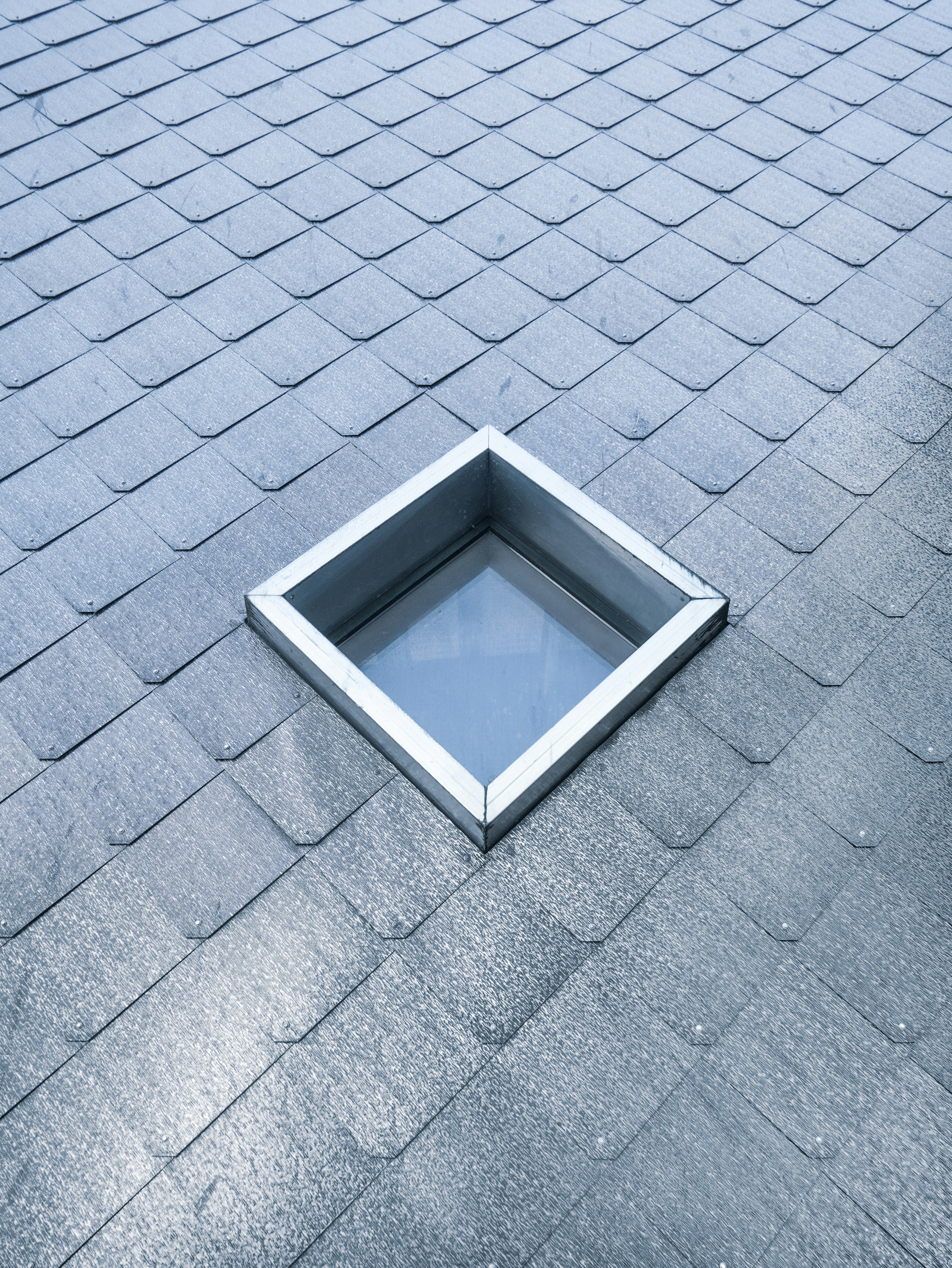 Aerial Study: Square Skylight Framed by Diamond Roof Tiles