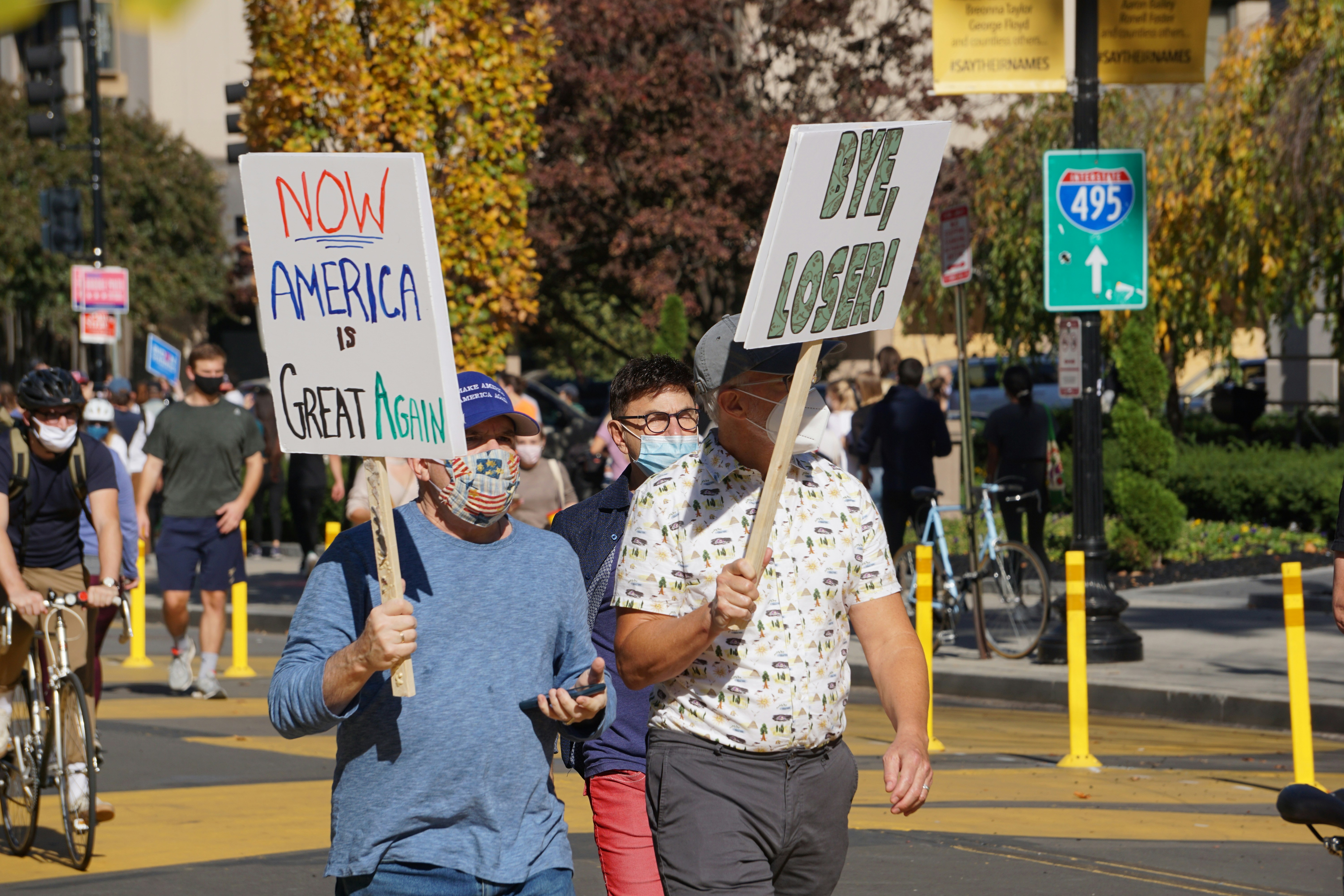 Two men with signs headed towards the White House after the presidential election was called for Joe Biden on November 7, 2020.