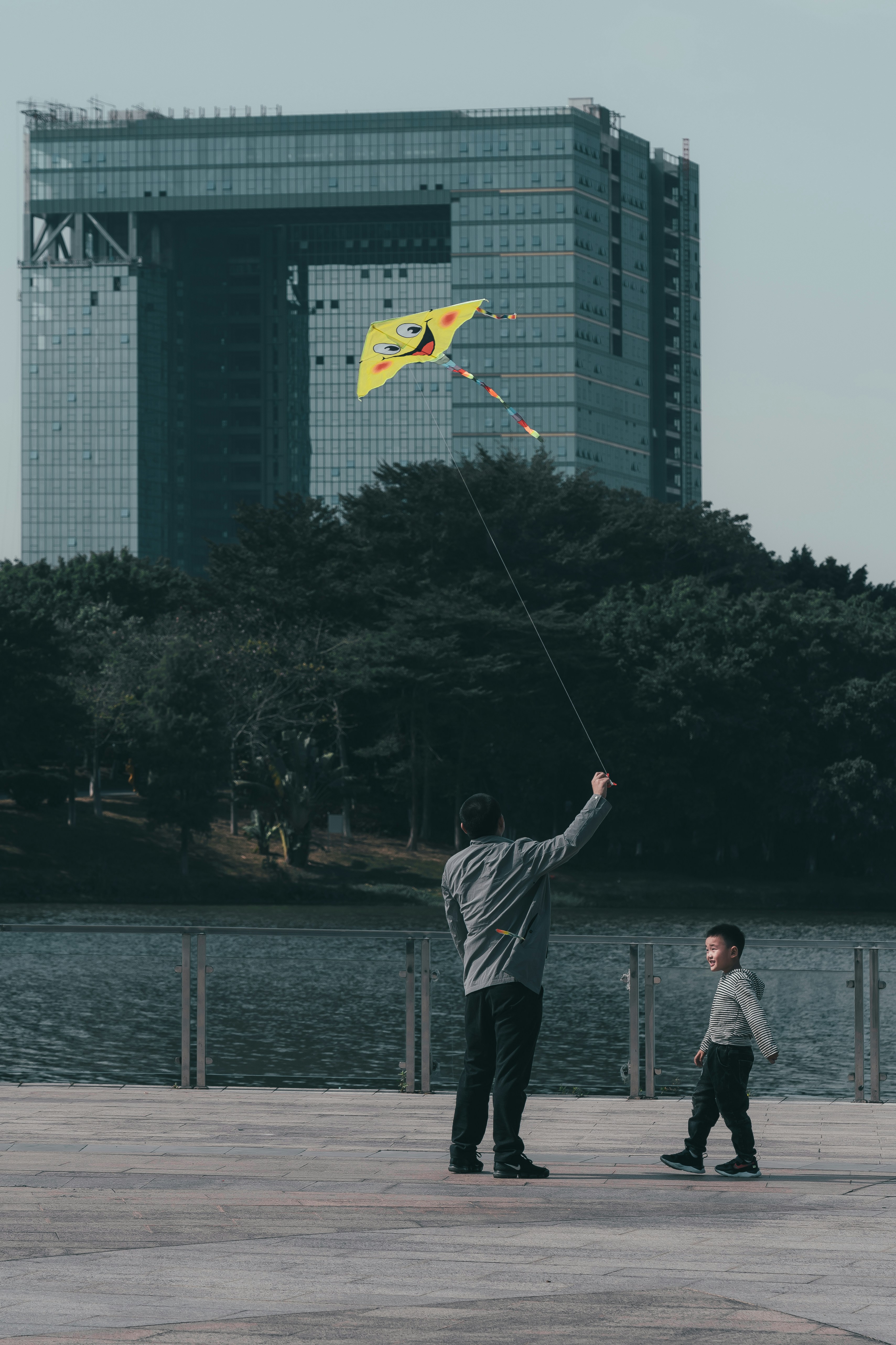 Lakeside Kite Launch Beneath a Glass-Fronted Skyline