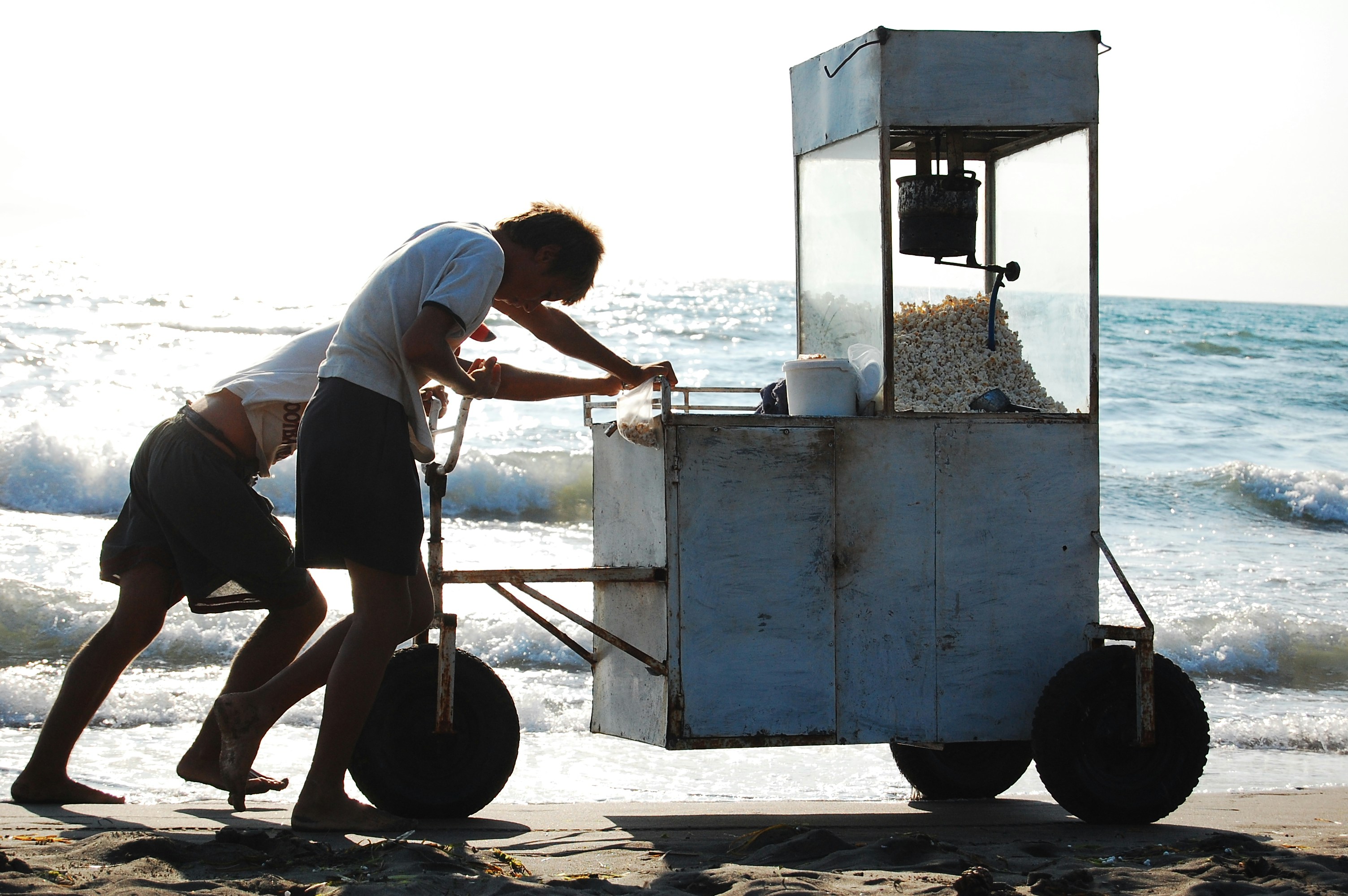 Three-portrait on a Seaside Cart: Sunlit Beach Vendor at Dusk