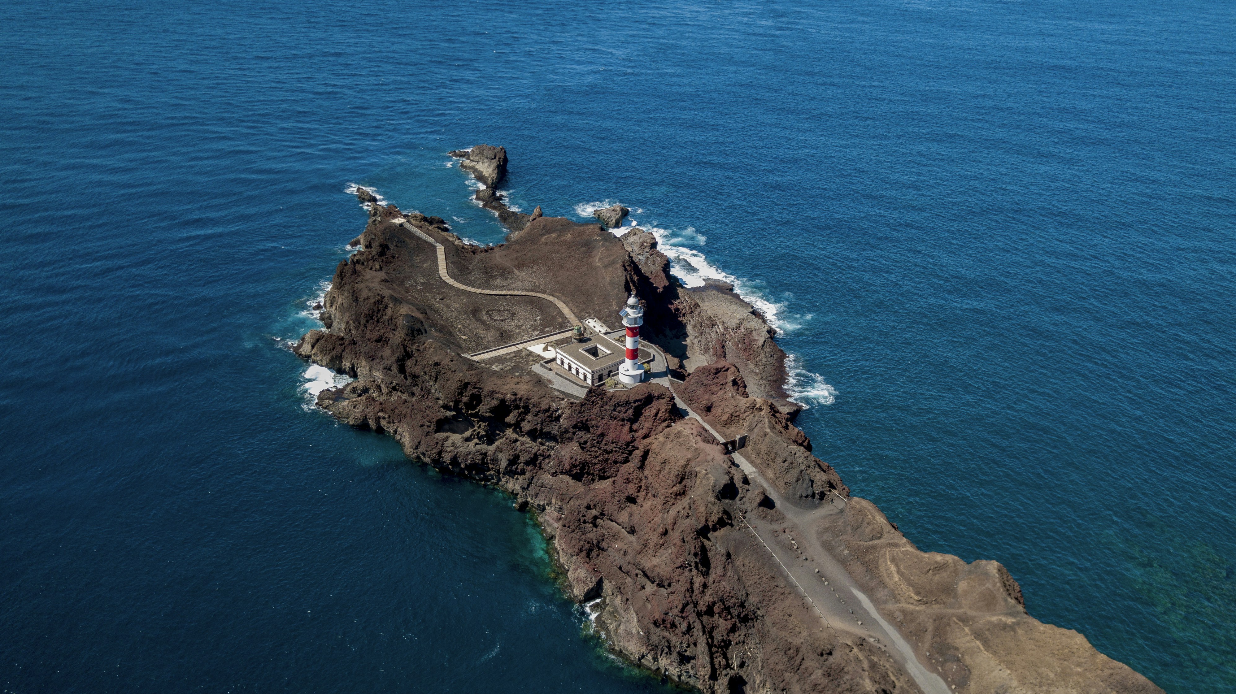 Lighthouse Sentinel on a Rugged Island Beside the Deep Blue