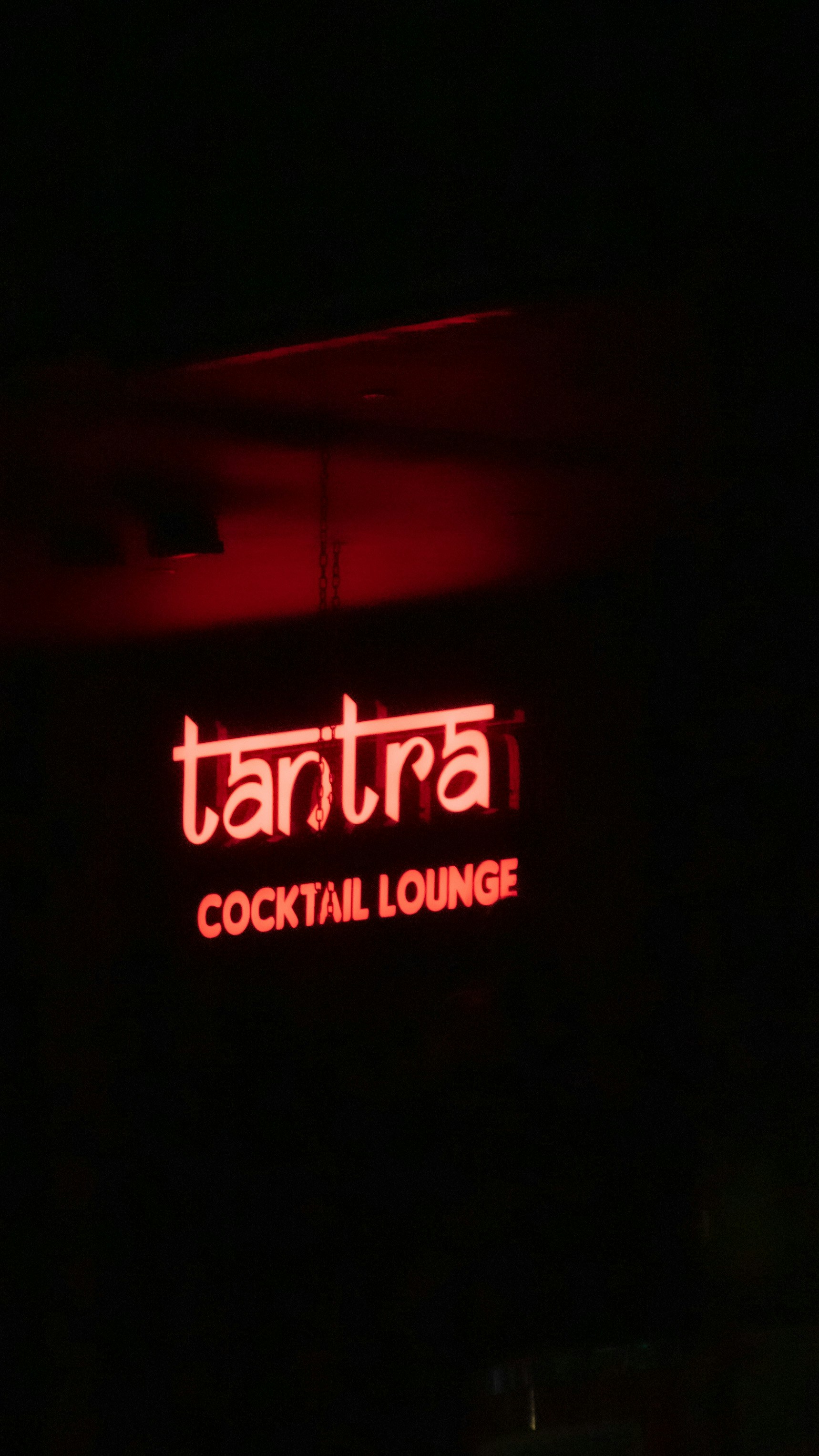 a neon sign is lit up in the dark