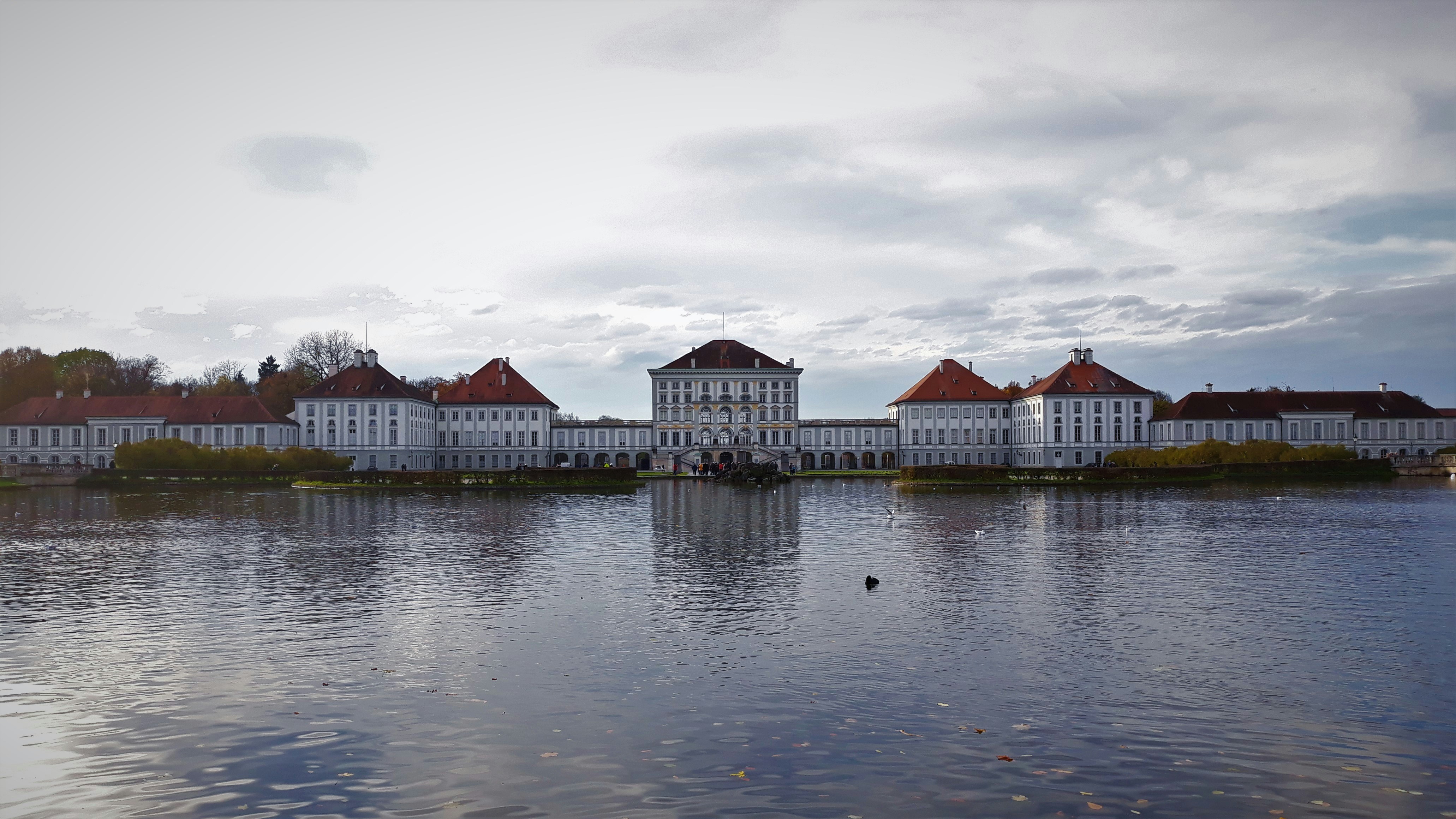 white and brown concrete building near body of water during daytime