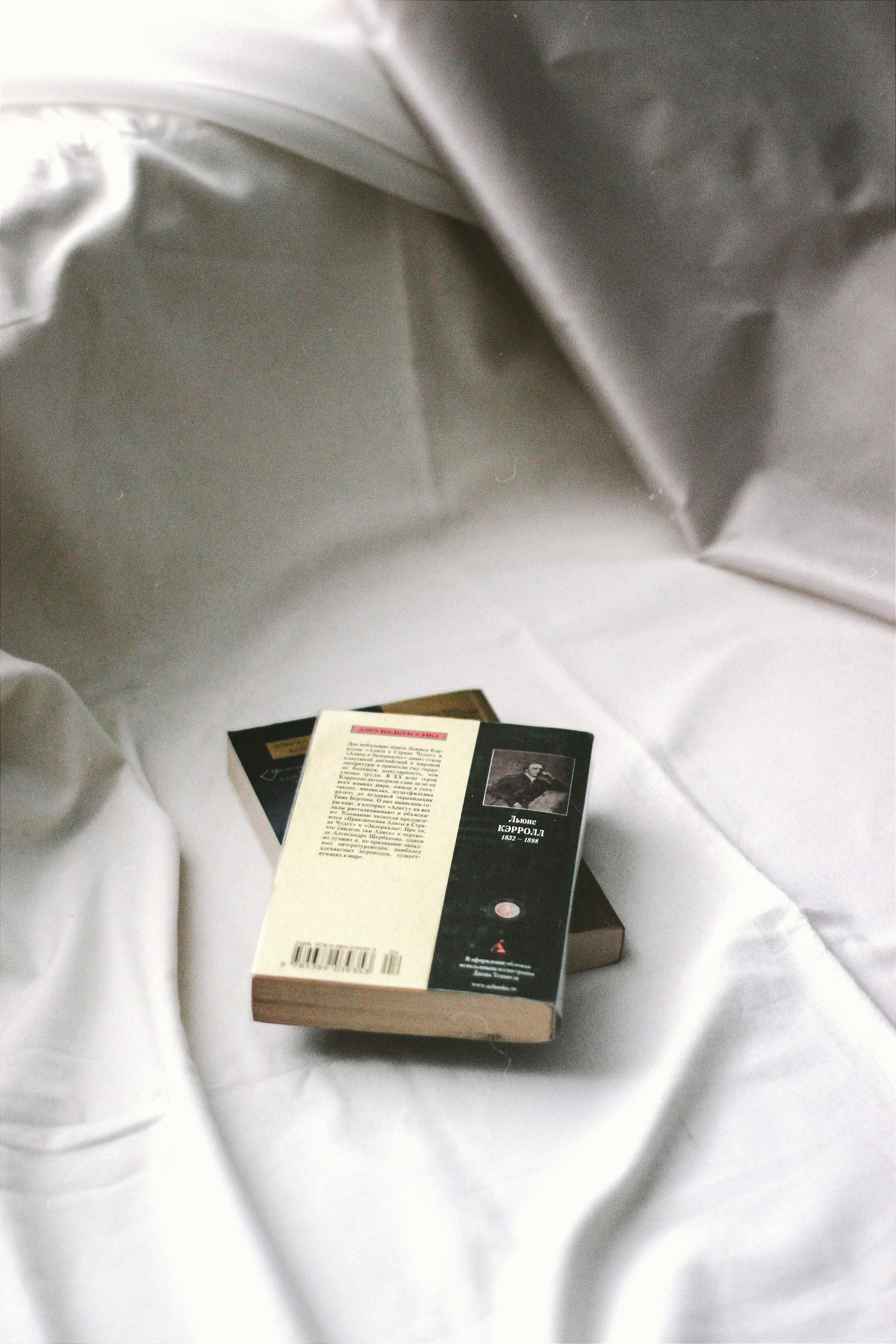 Books stacked on a softly draped white fabric backdrop.