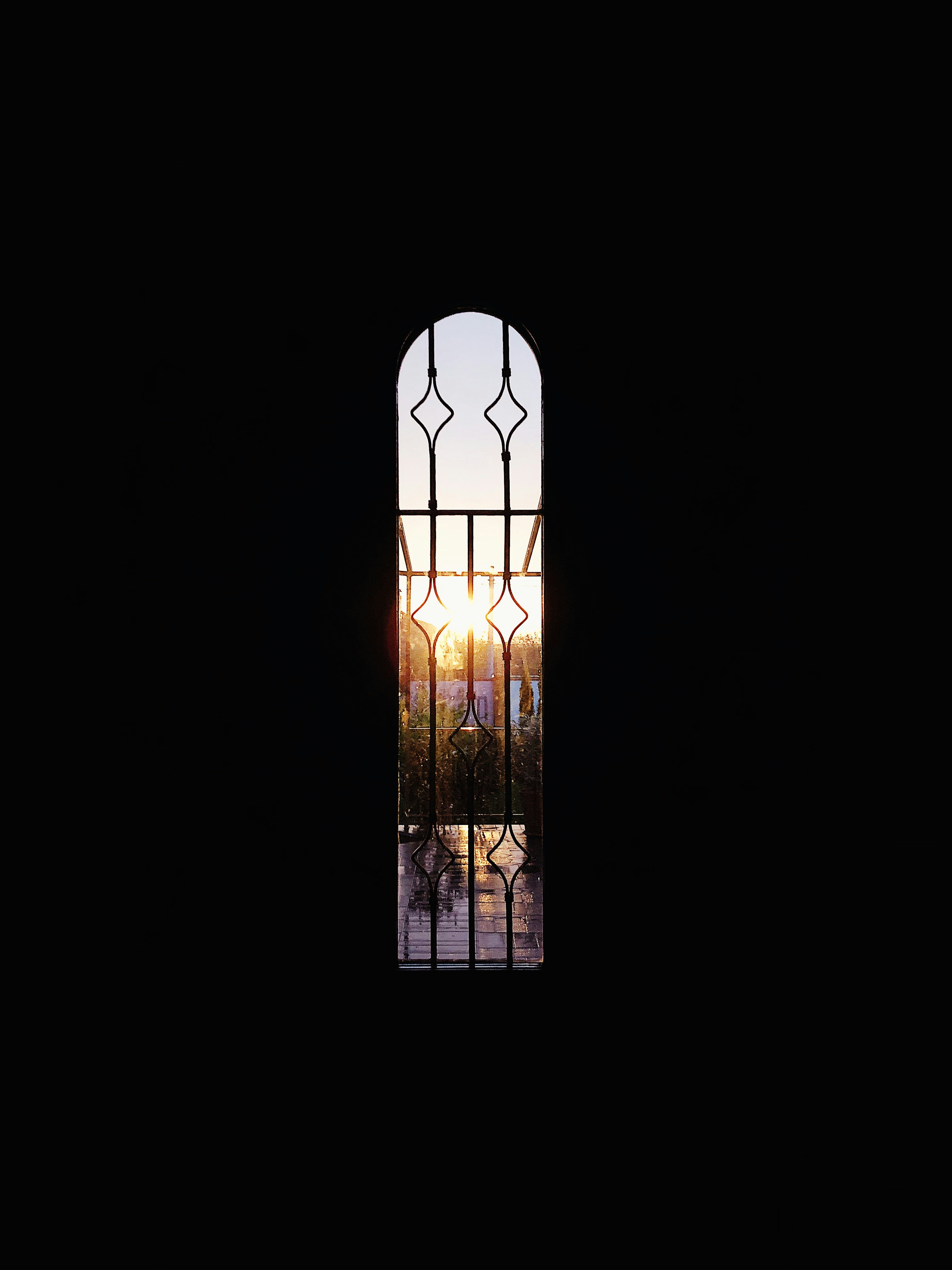 Doorway to Evening: Sunset Framing a Narrow Iron Grille