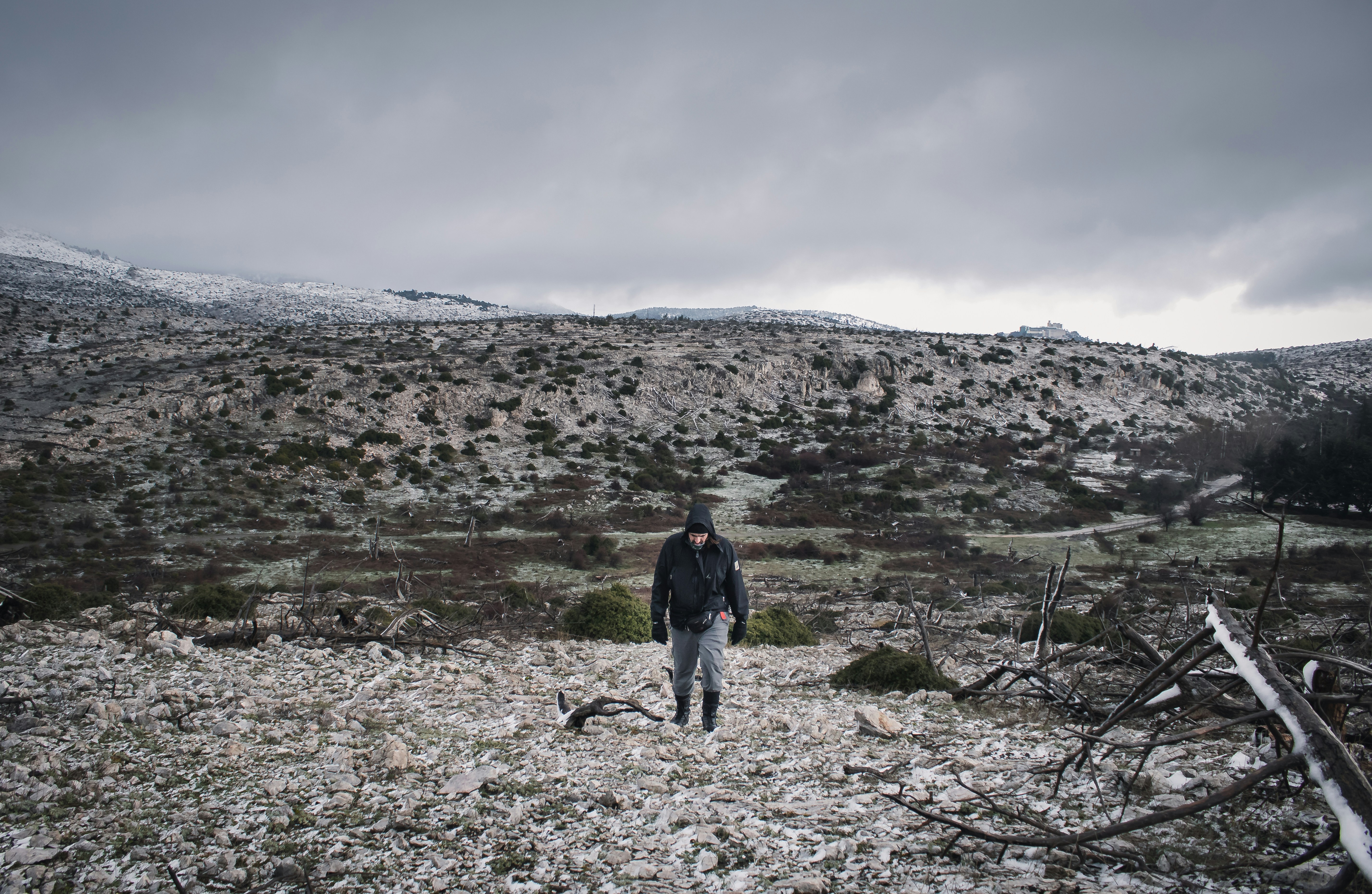 Lone Wanderer on a Pebble Plain Under a Brooding Sky
