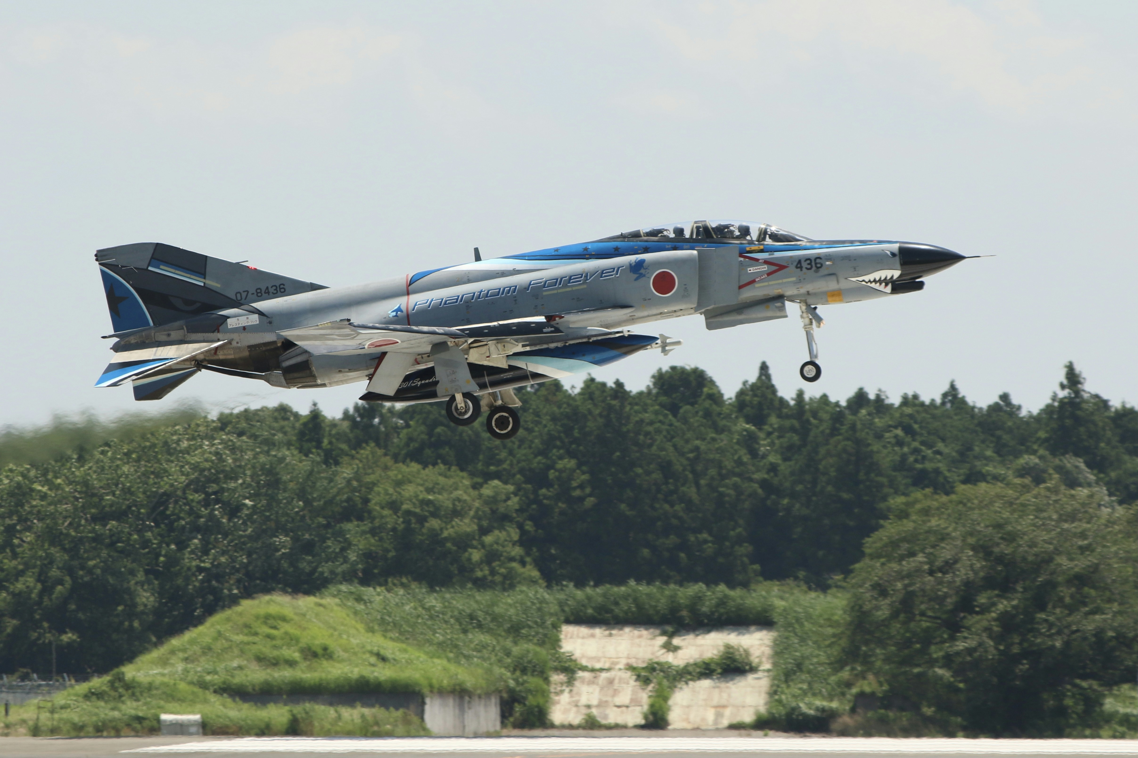 Blue and white jet plane flying over green trees during daytime photo ...