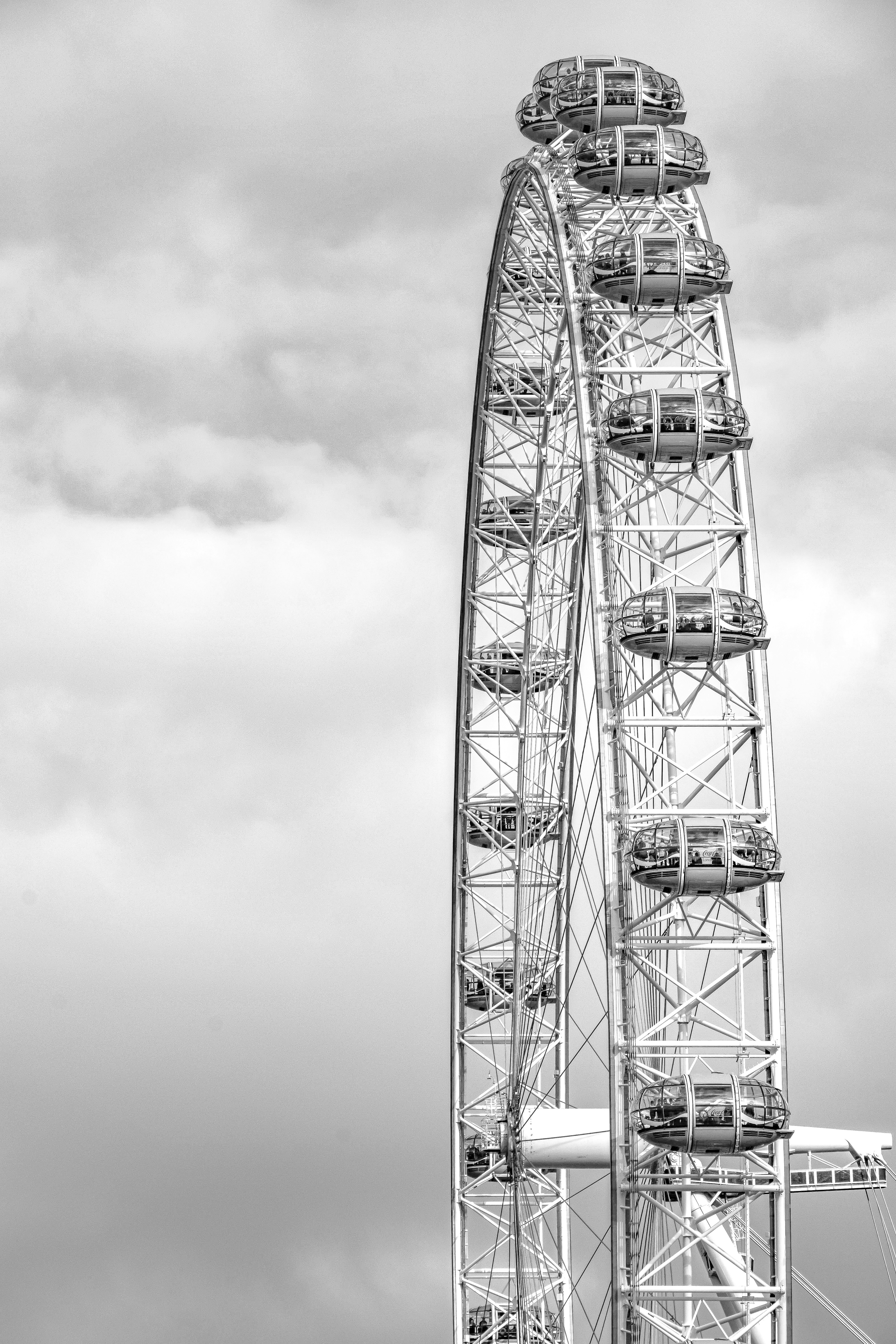 Monochrome Orbit: A Ferris Wheel's Steel Lattice Rises Against the Sky