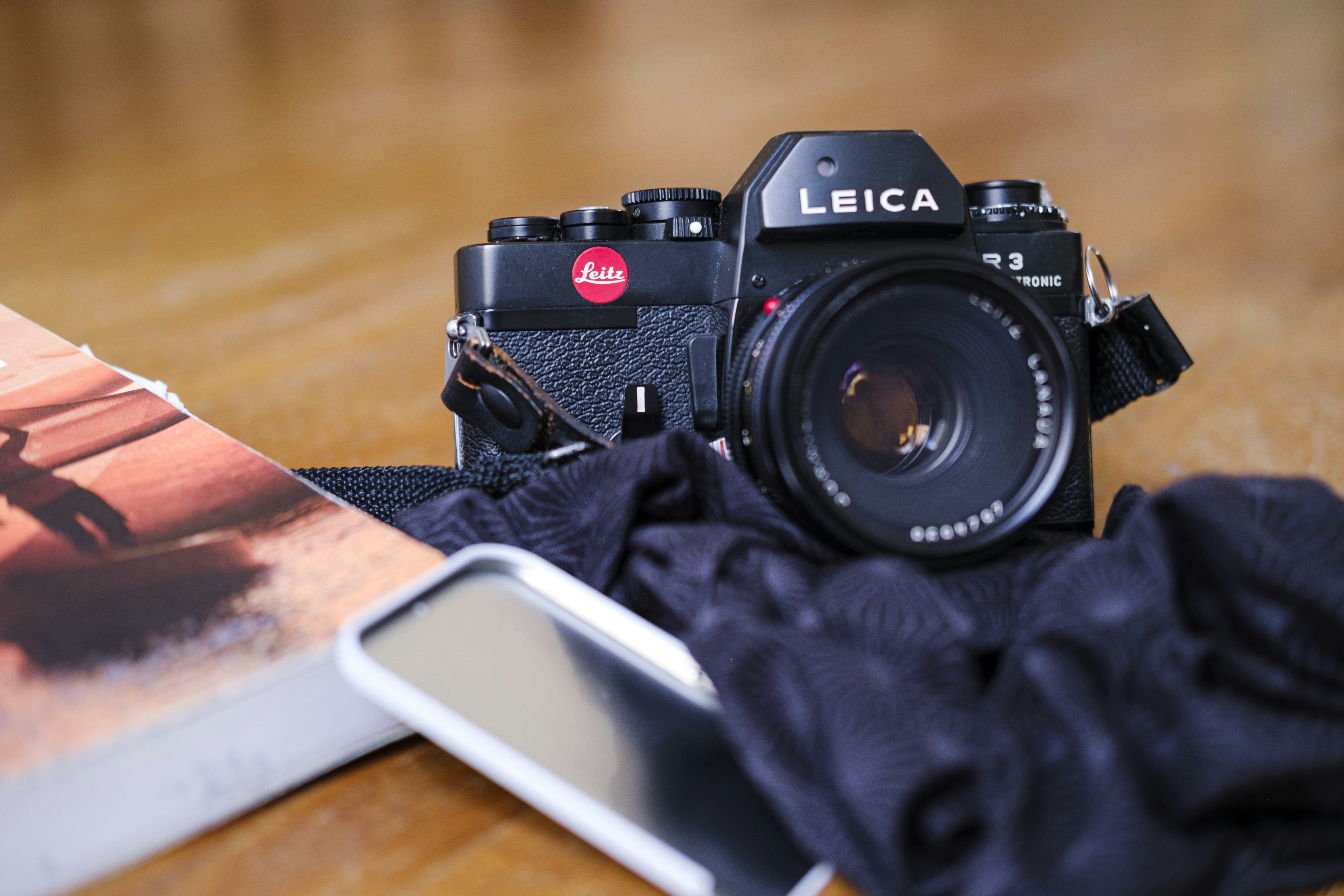 Leica Glow: A Retro Lens and Modern Glass resting on a wooden desk