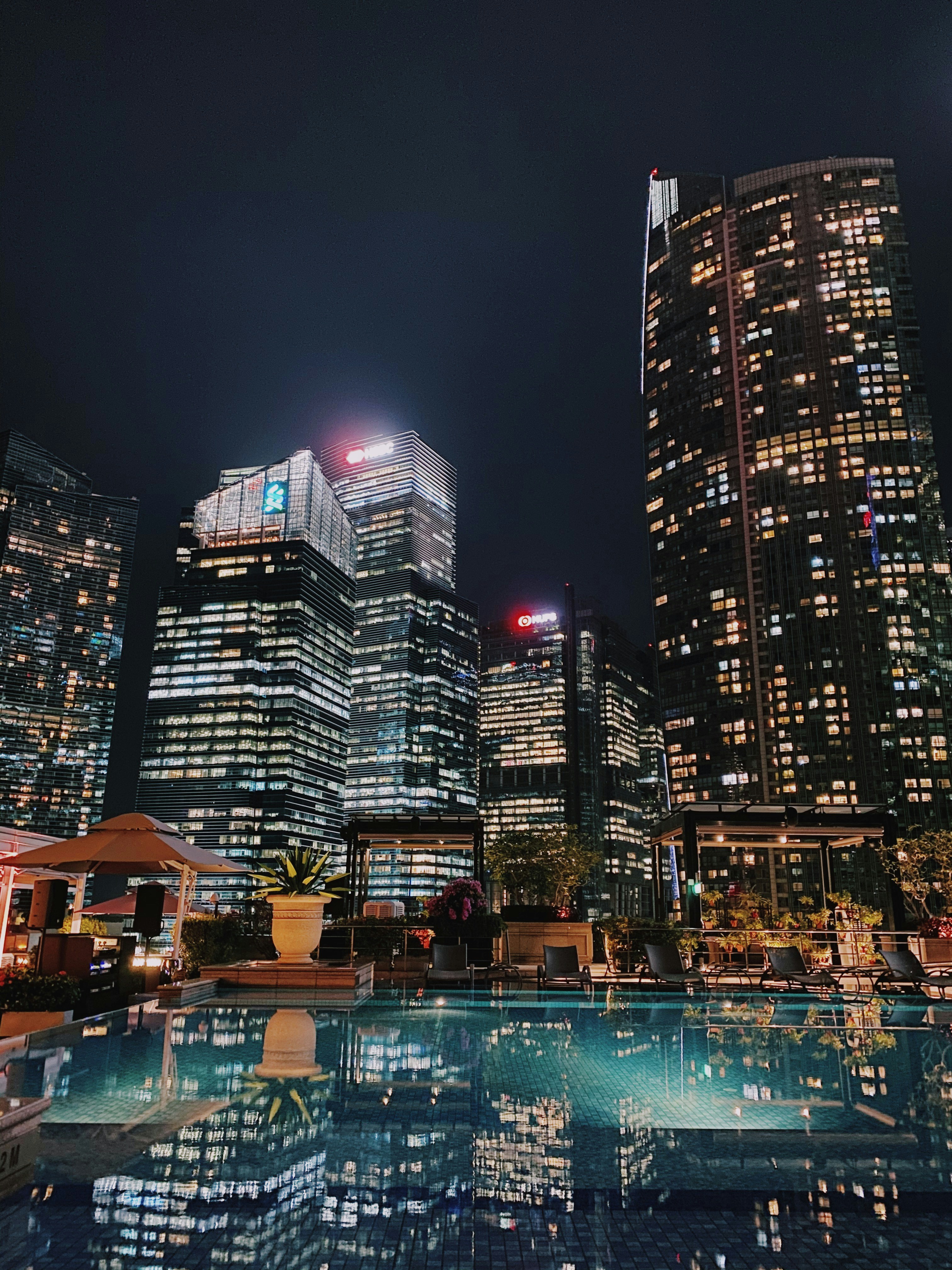 High rise buildings near body of water during night time photo – Free ...