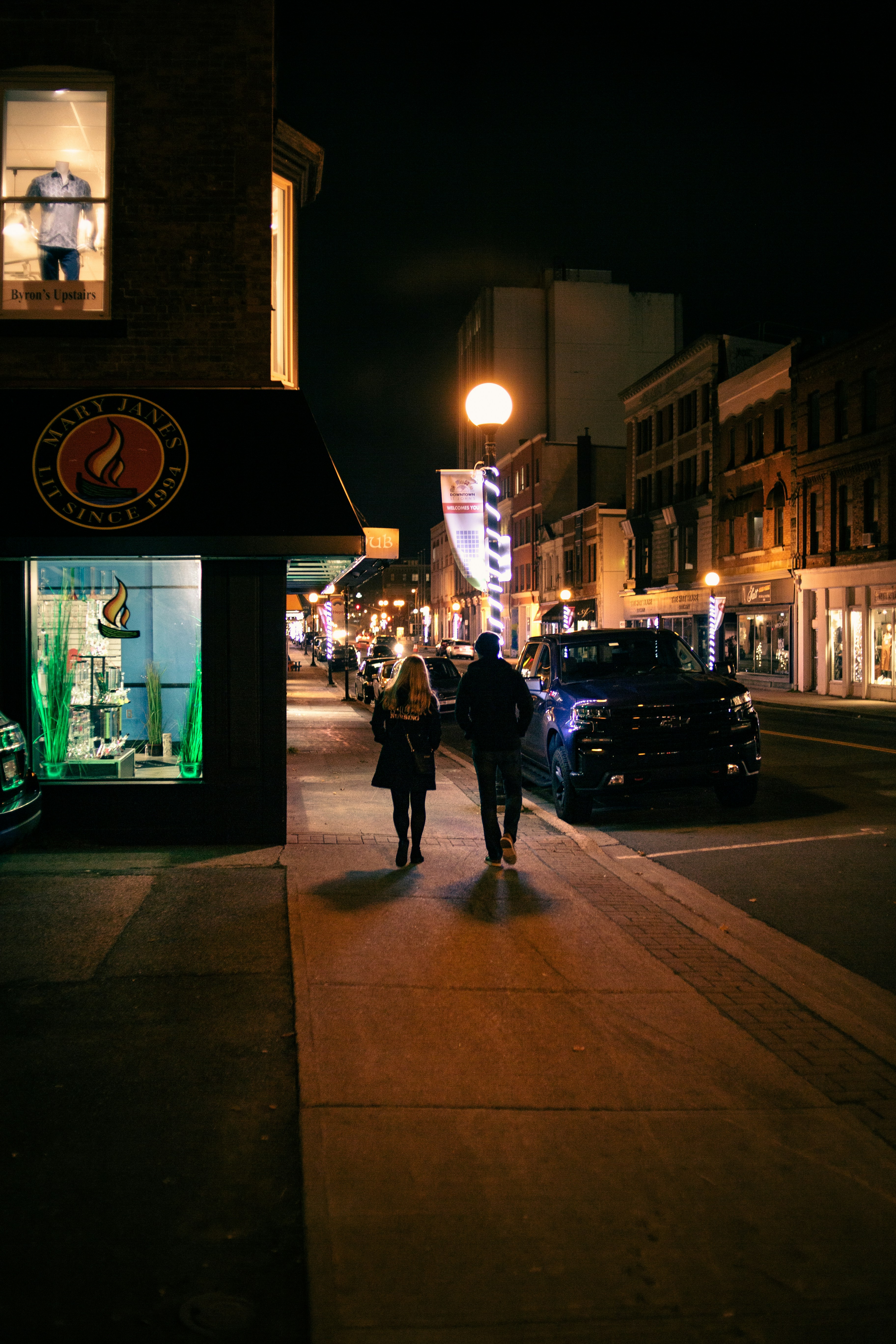 people walking on sidewalk during night time