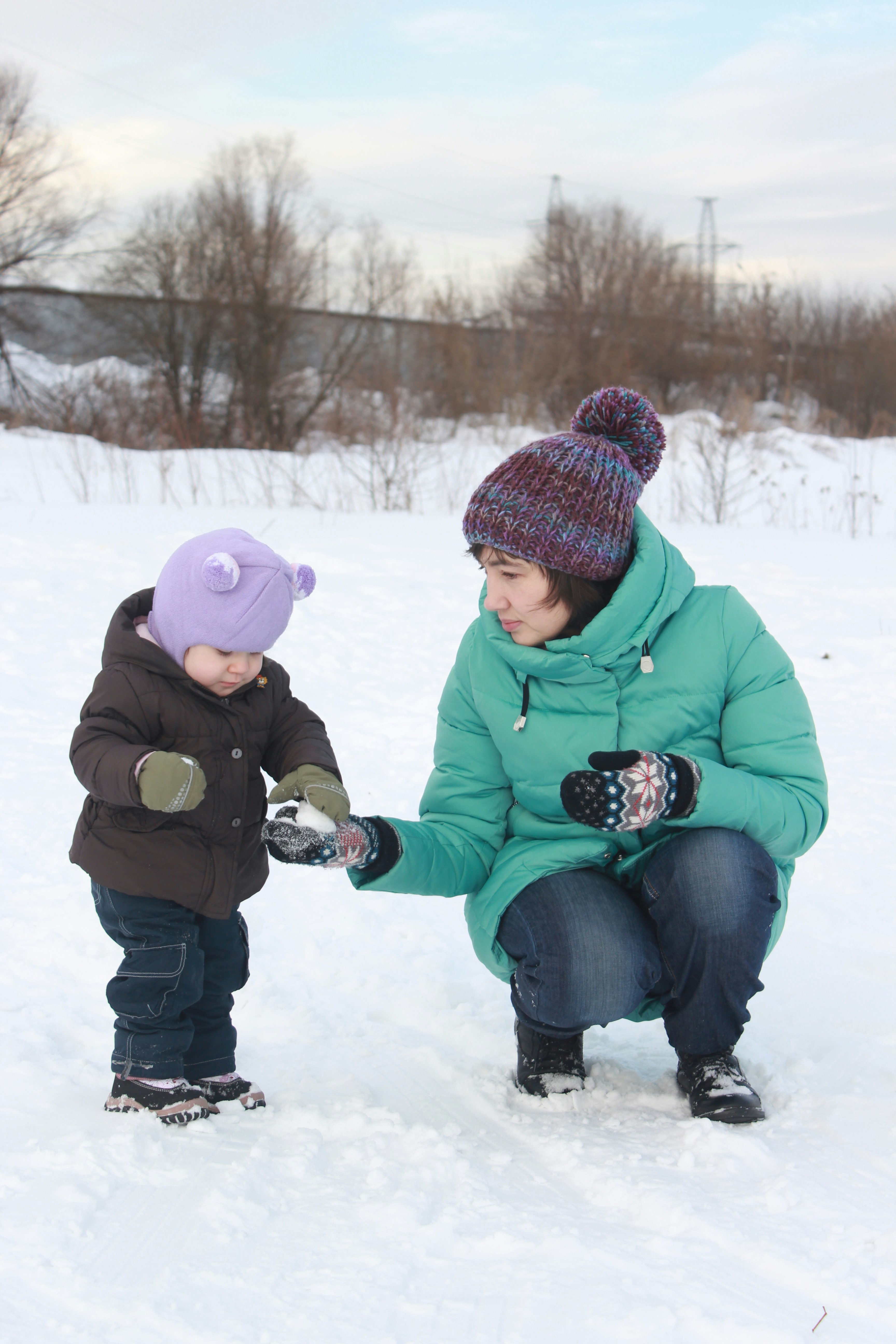 Snowball Lesson: A Mother Helps Her Child in a Quiet Winter Field