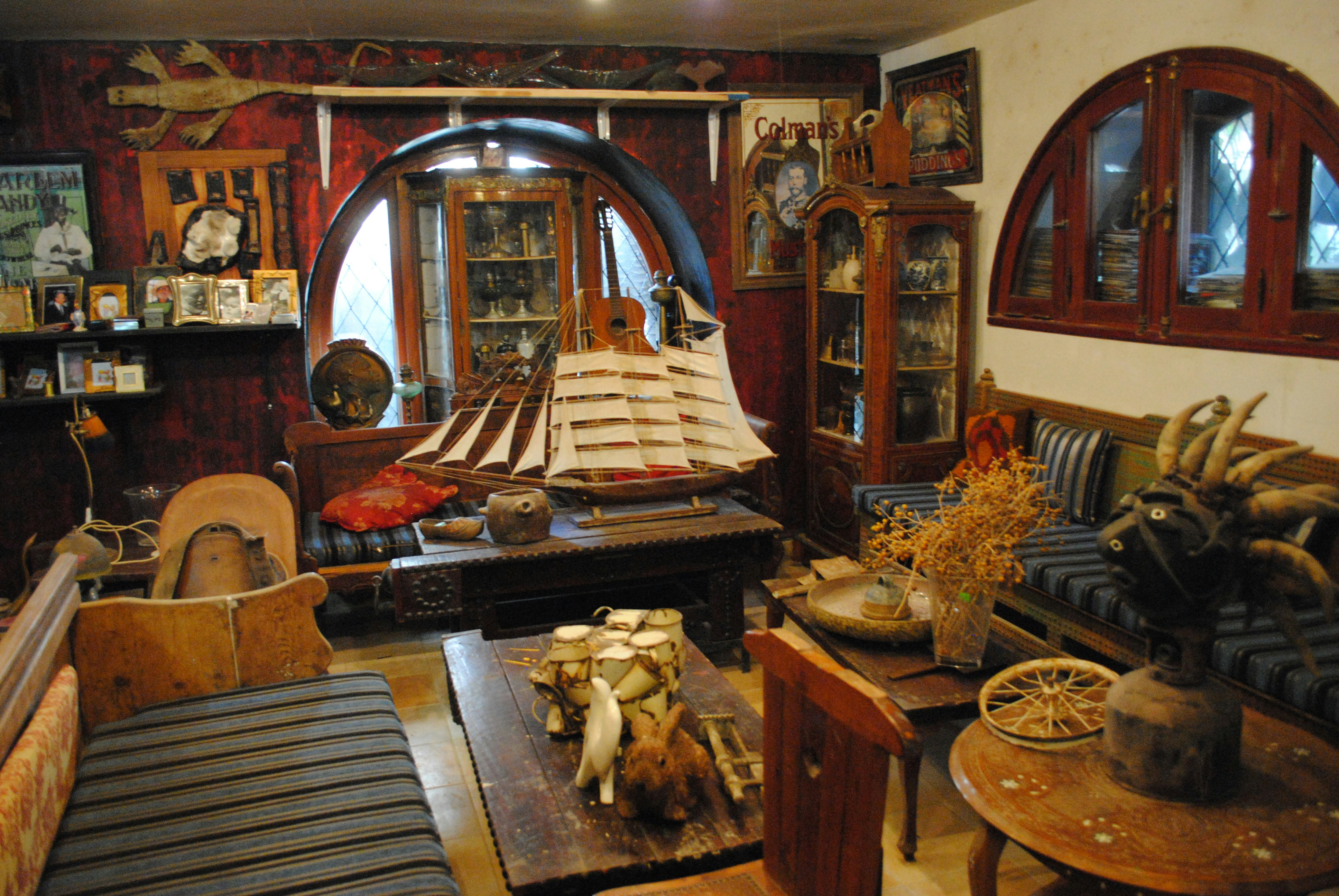 Cozy interior showcasing vintage nautical decor, featuring a detailed ship model and rustic furnishings. The warm ambiance invites exploration.