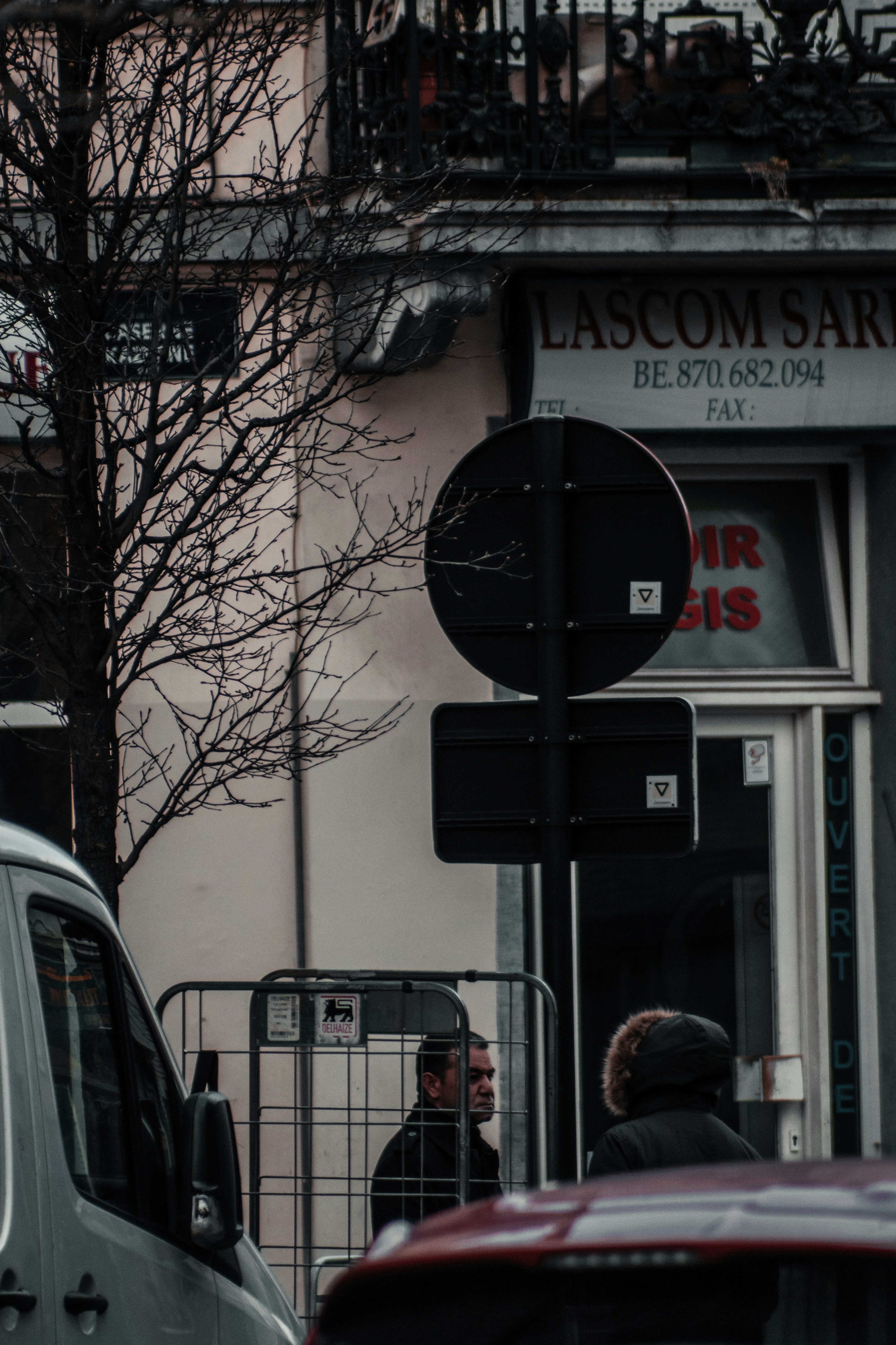 Two individuals engaged in conversation amidst a backdrop of urban signage and architecture.