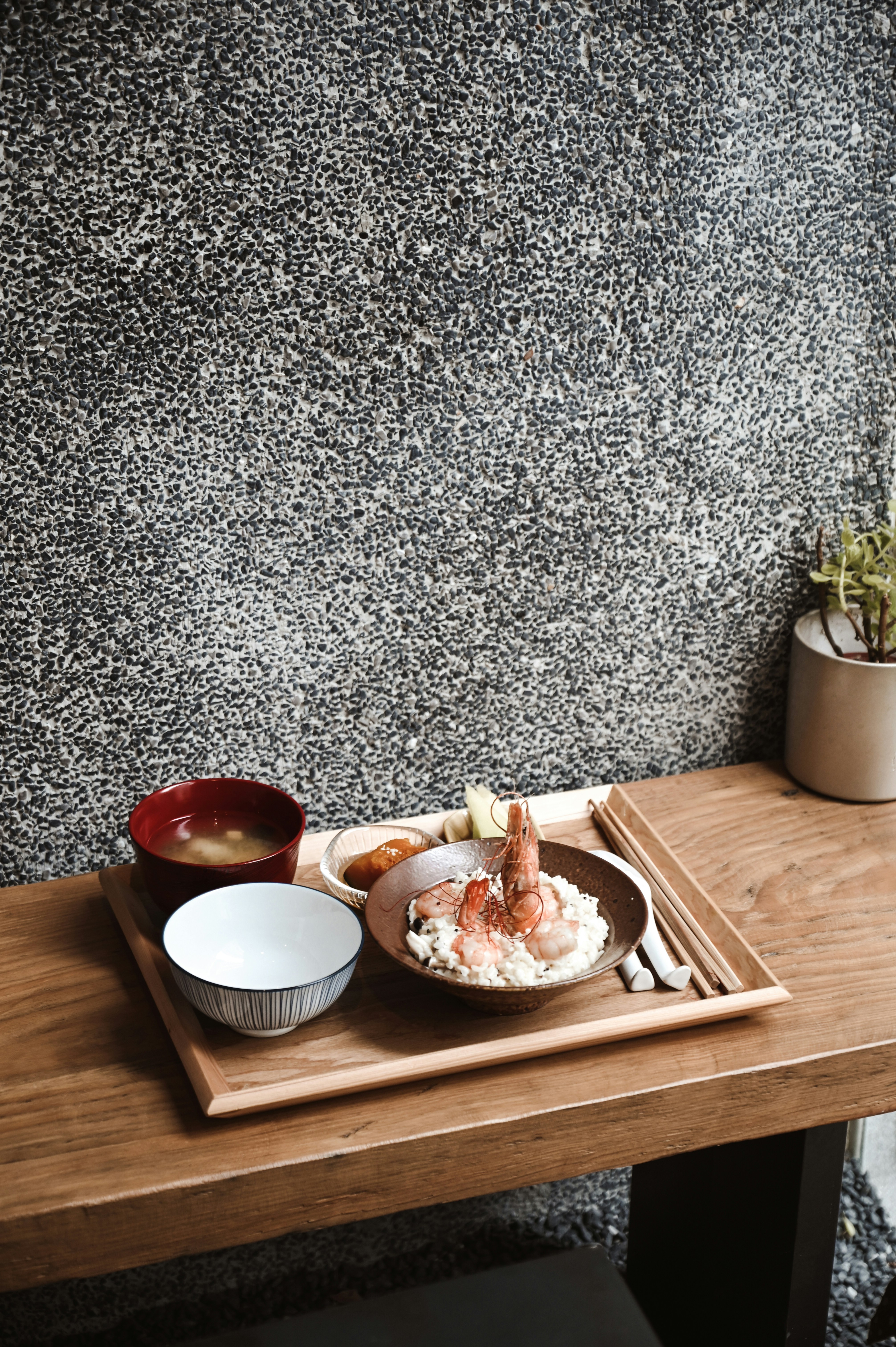 Shrimp and Rice on a Wooden Tray: A Quiet Café Moment by a Textured Wall