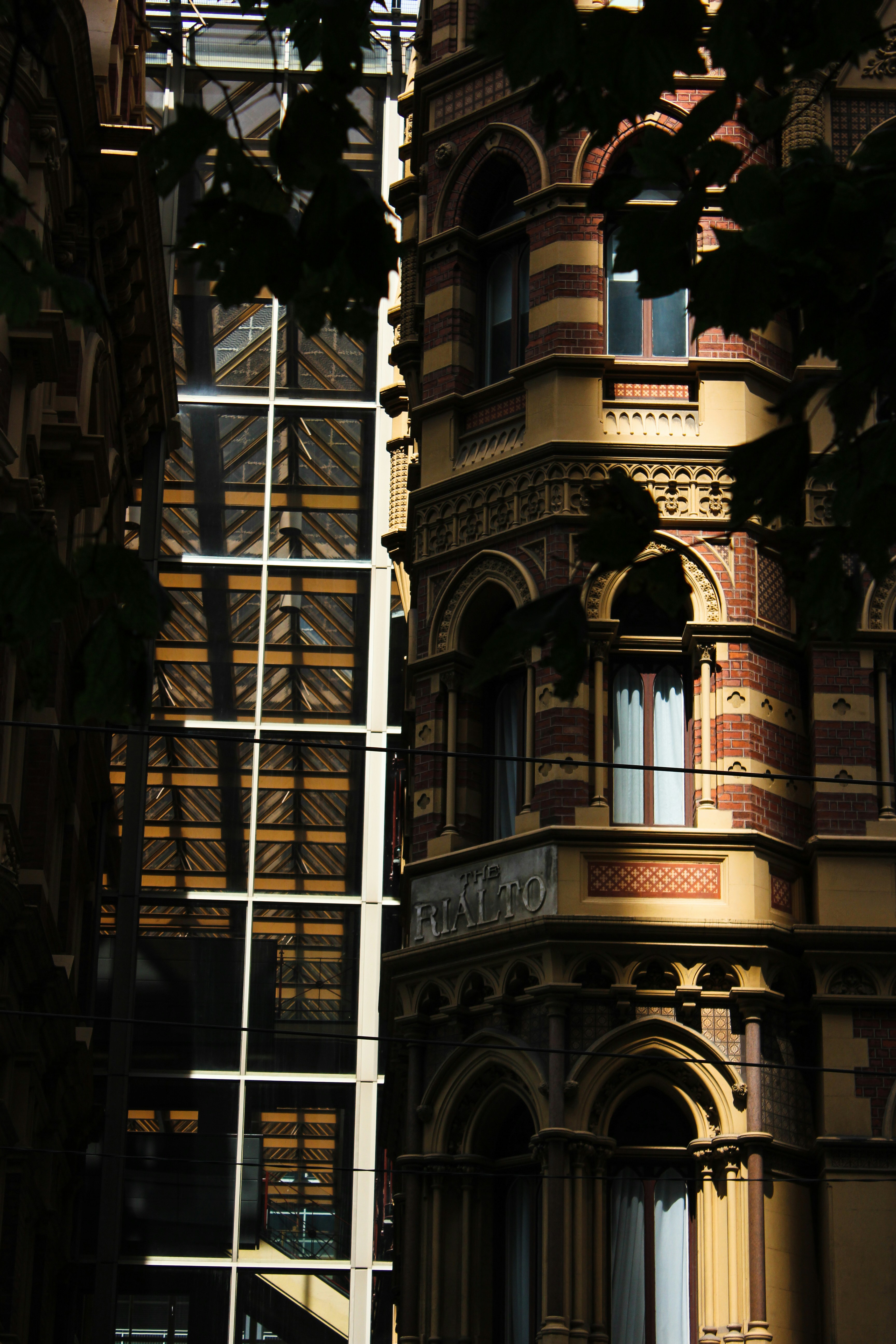 Ornate Facade Framed by Shadows Between Glass and Brick