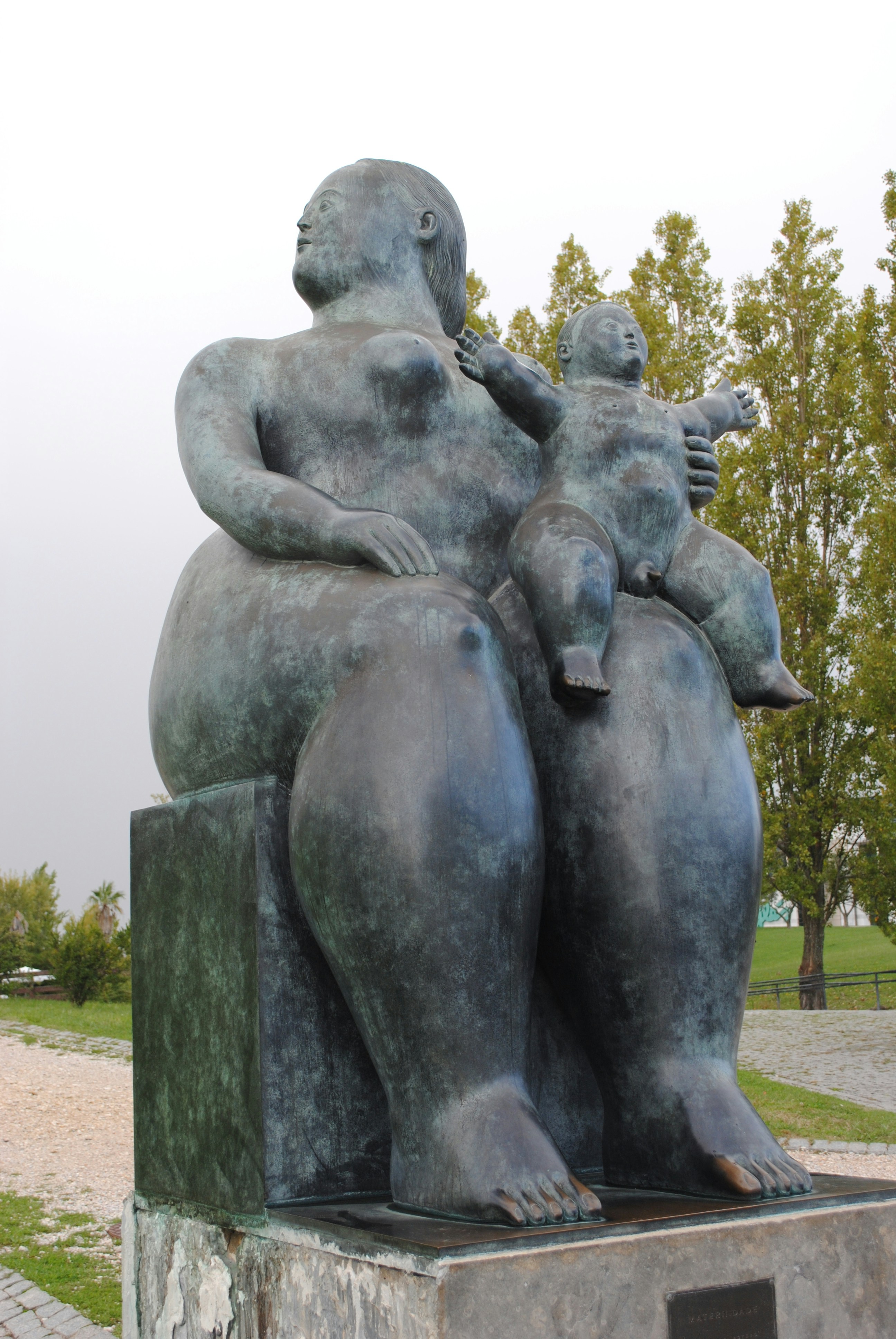 Bronze Embrace: A Father and Child Statue in Park Tranquility