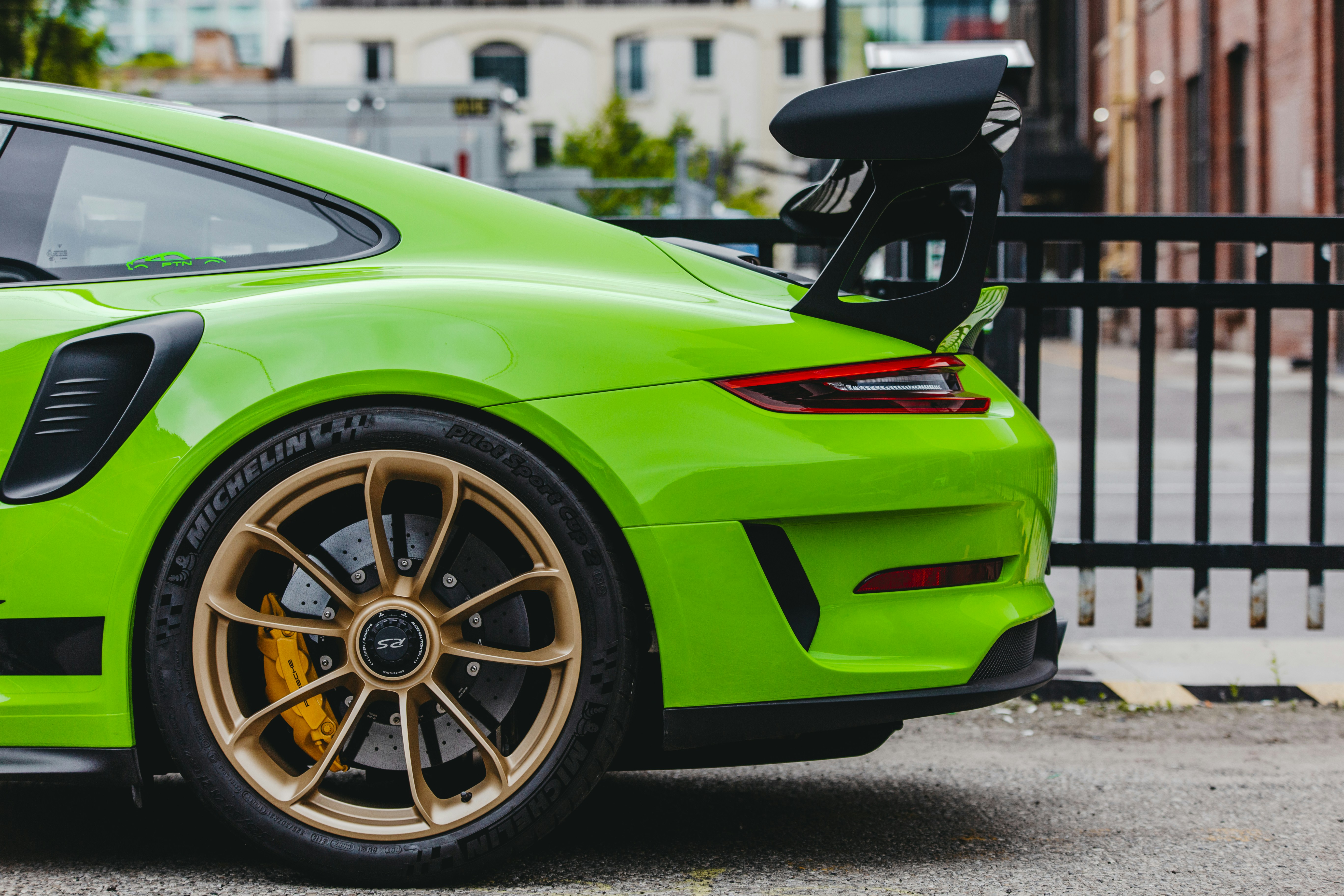 Porsche 911 verde aparcado cerca de un edificio blanco durante el día ...