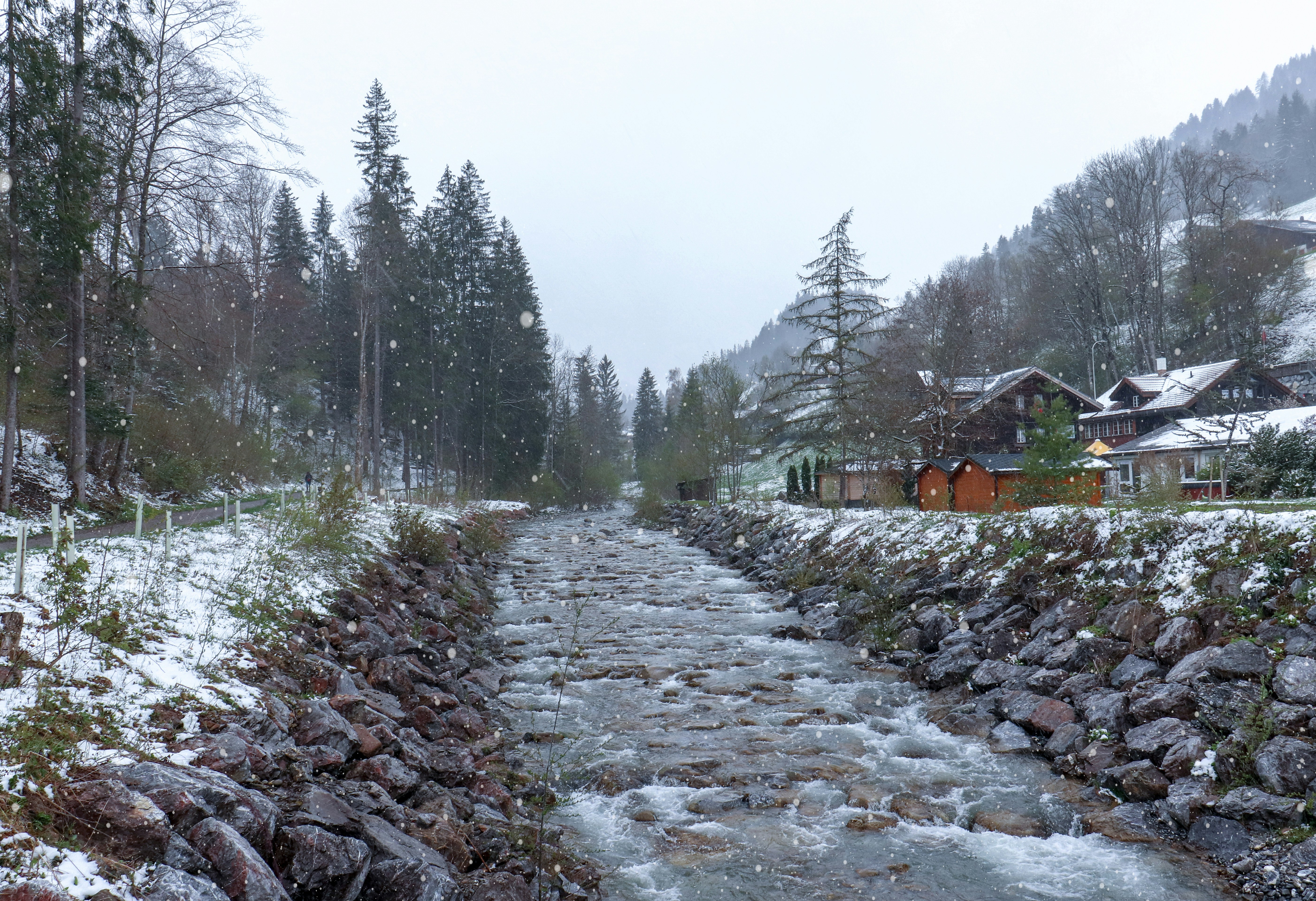 Snowbound Canal Framing a Quiet Alpine Village