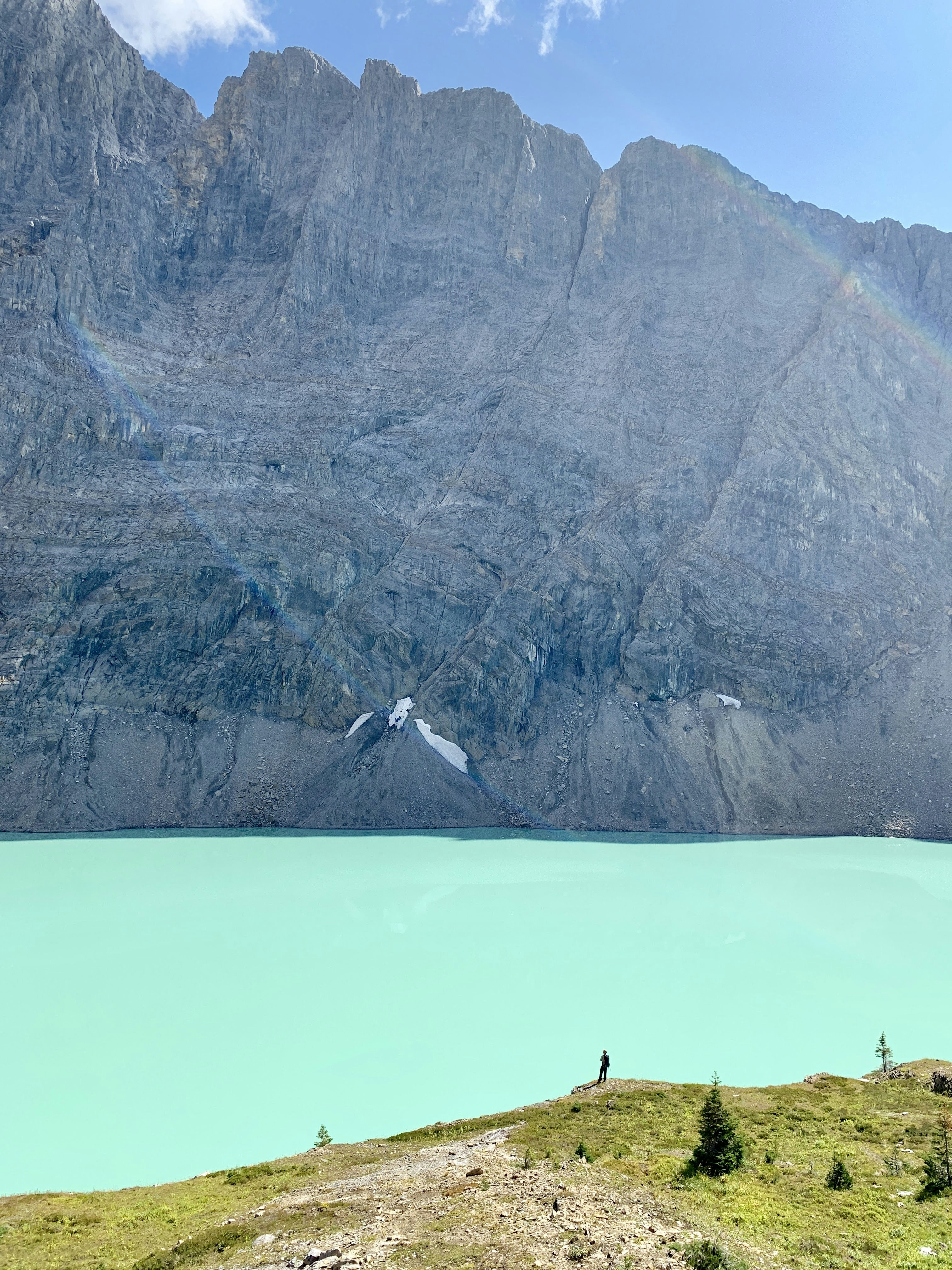 Lone Figure at the Turquoise Glacial Lake Beneath the Granite Wall