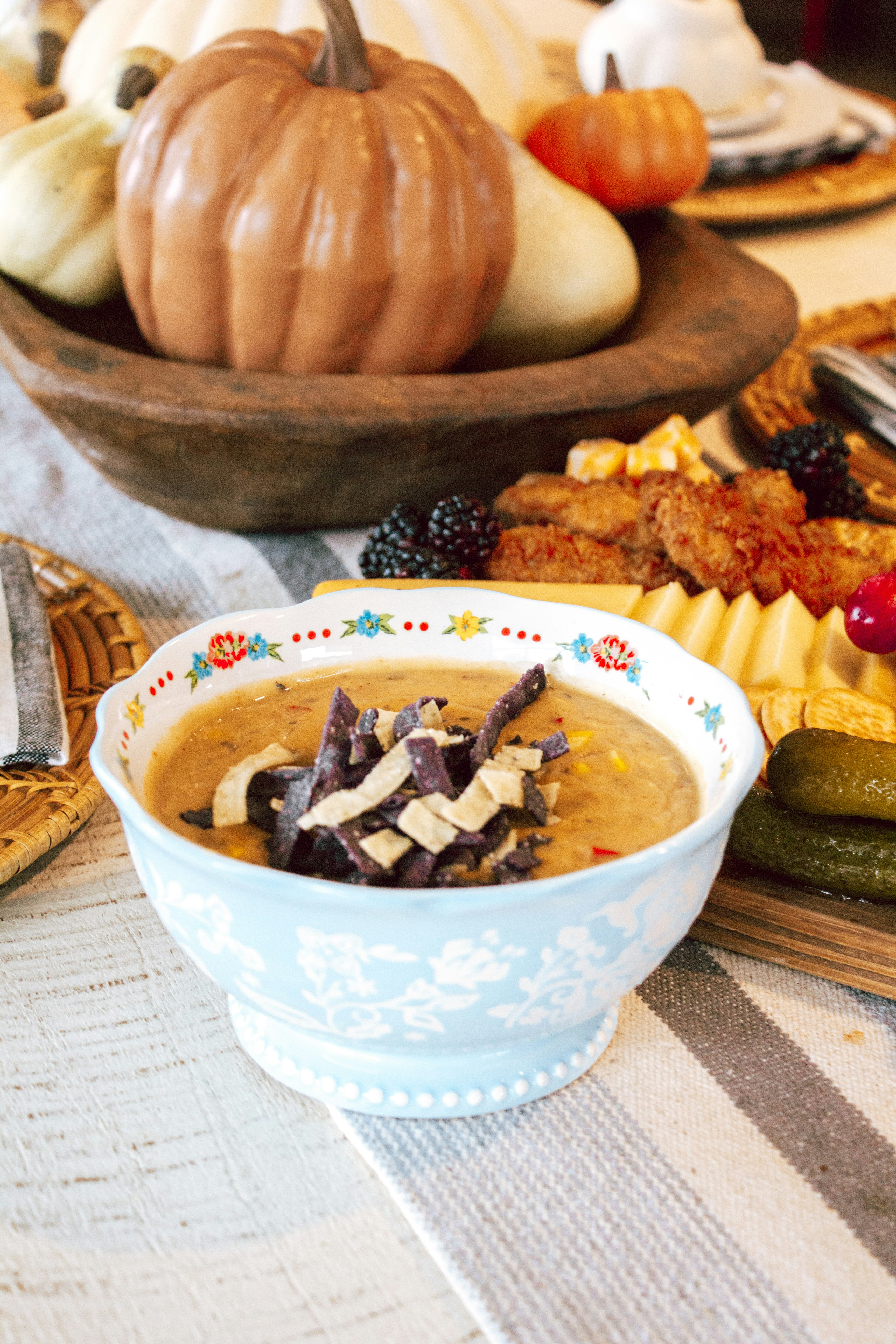 Creamy Soup Crowned with Dark Shards Amid a Harvest Spread