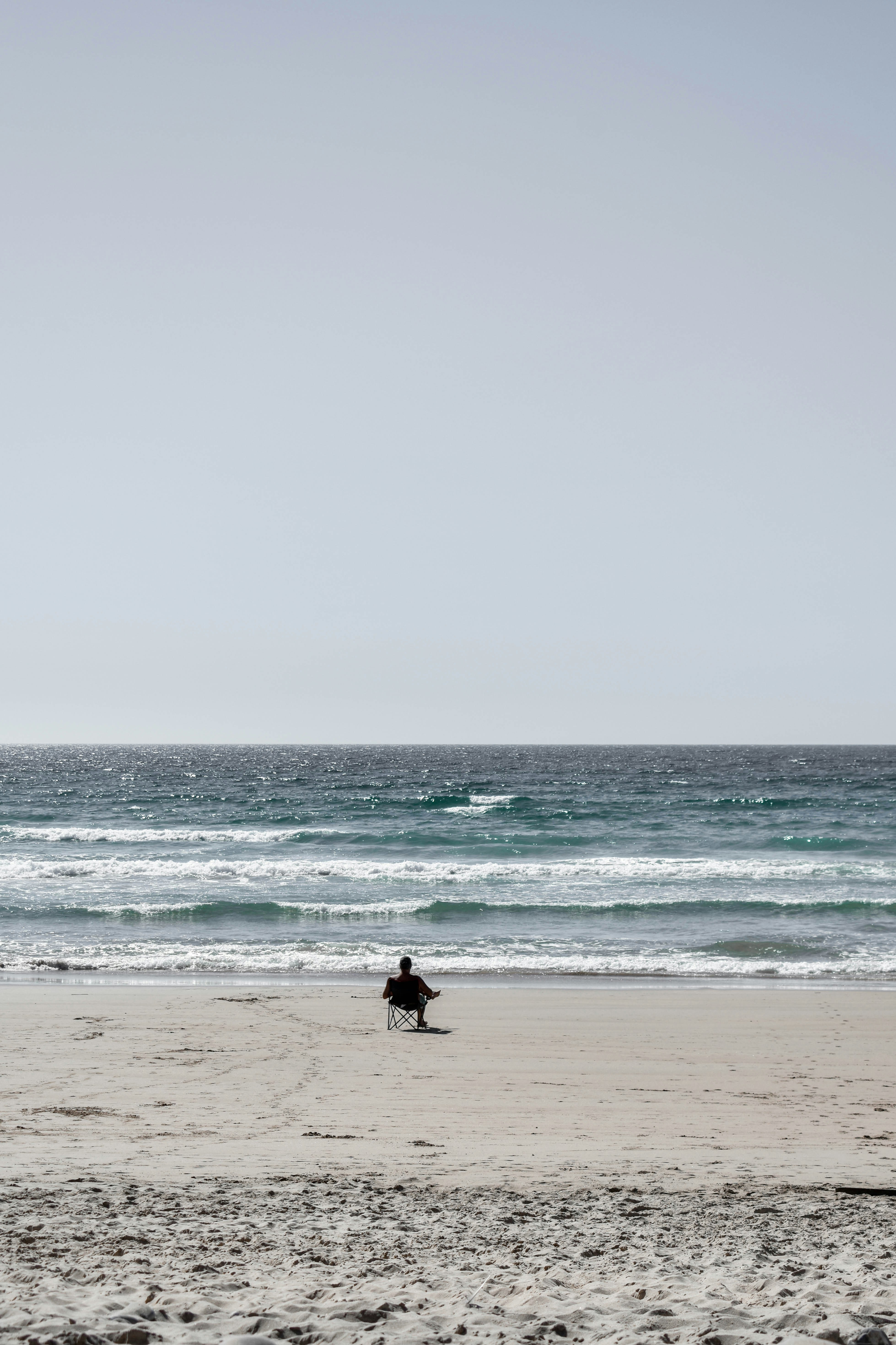 Solitary Surfer: A Lone Figure at the Edge of the Ocean