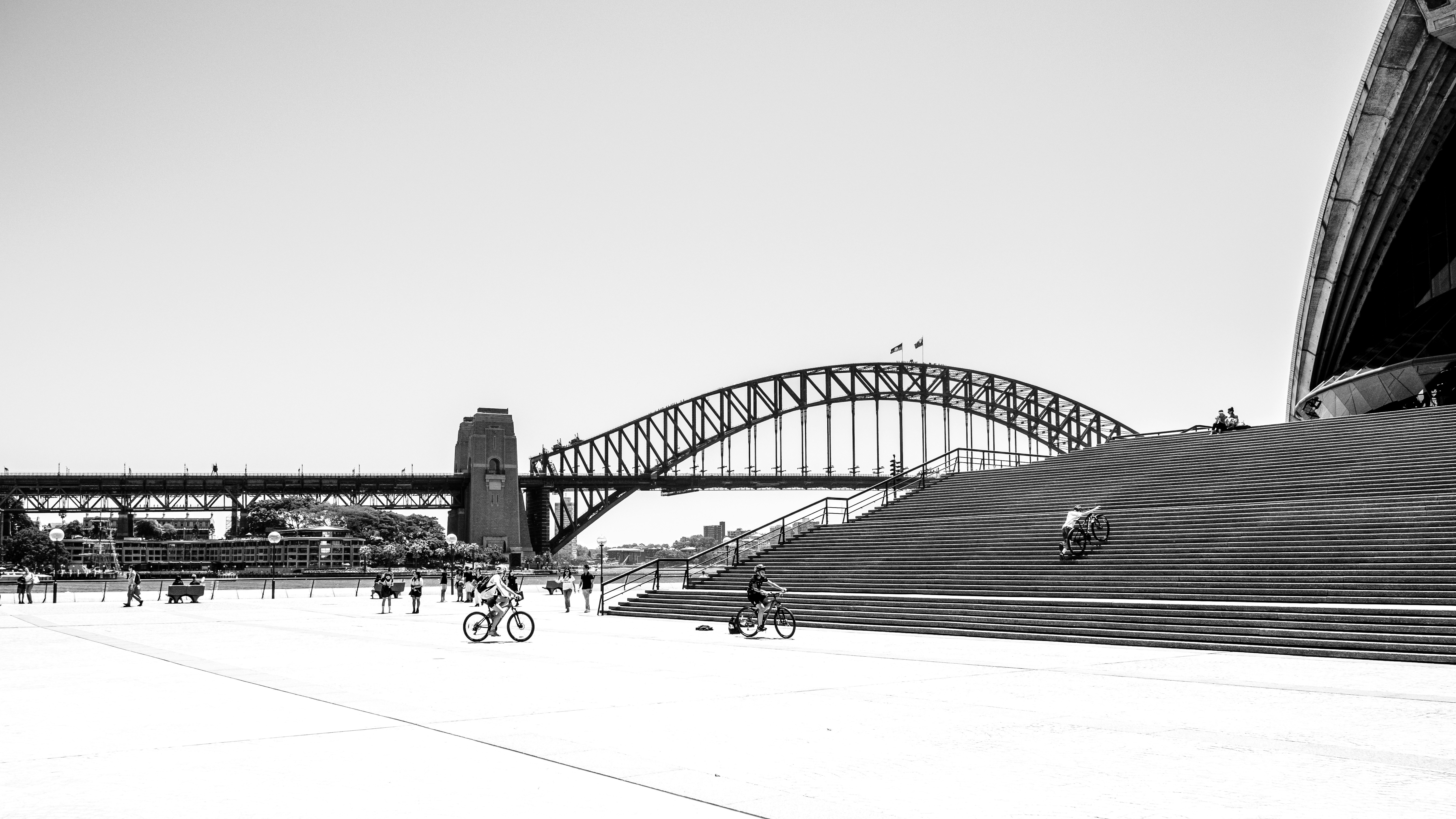 Harbor Arch in Mono: Bicycles Across a Quiet Stadium Terrace