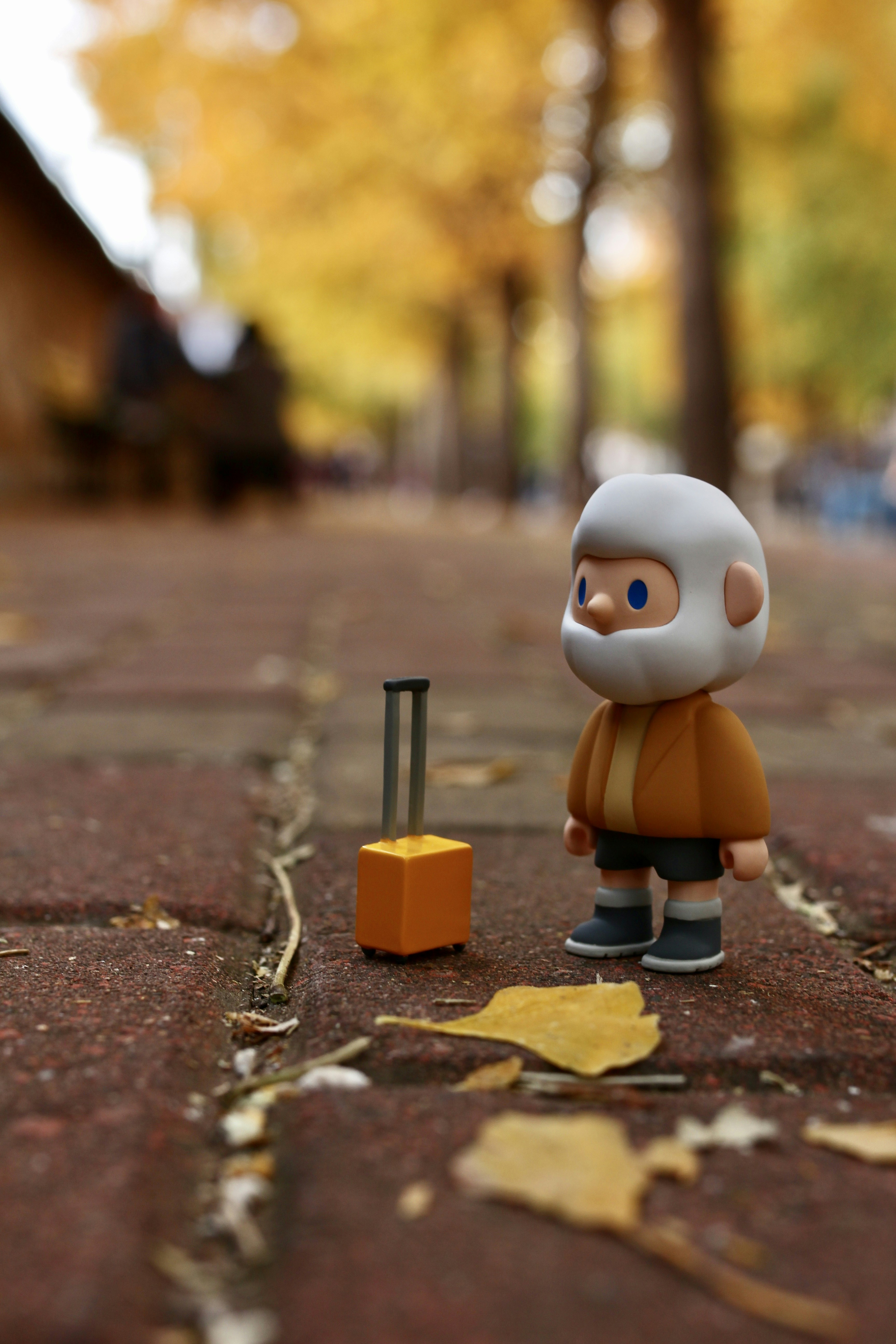 Small Wanderer at Autumn Alley: A Toy Figure Faces Off Against a Tiny Lantern