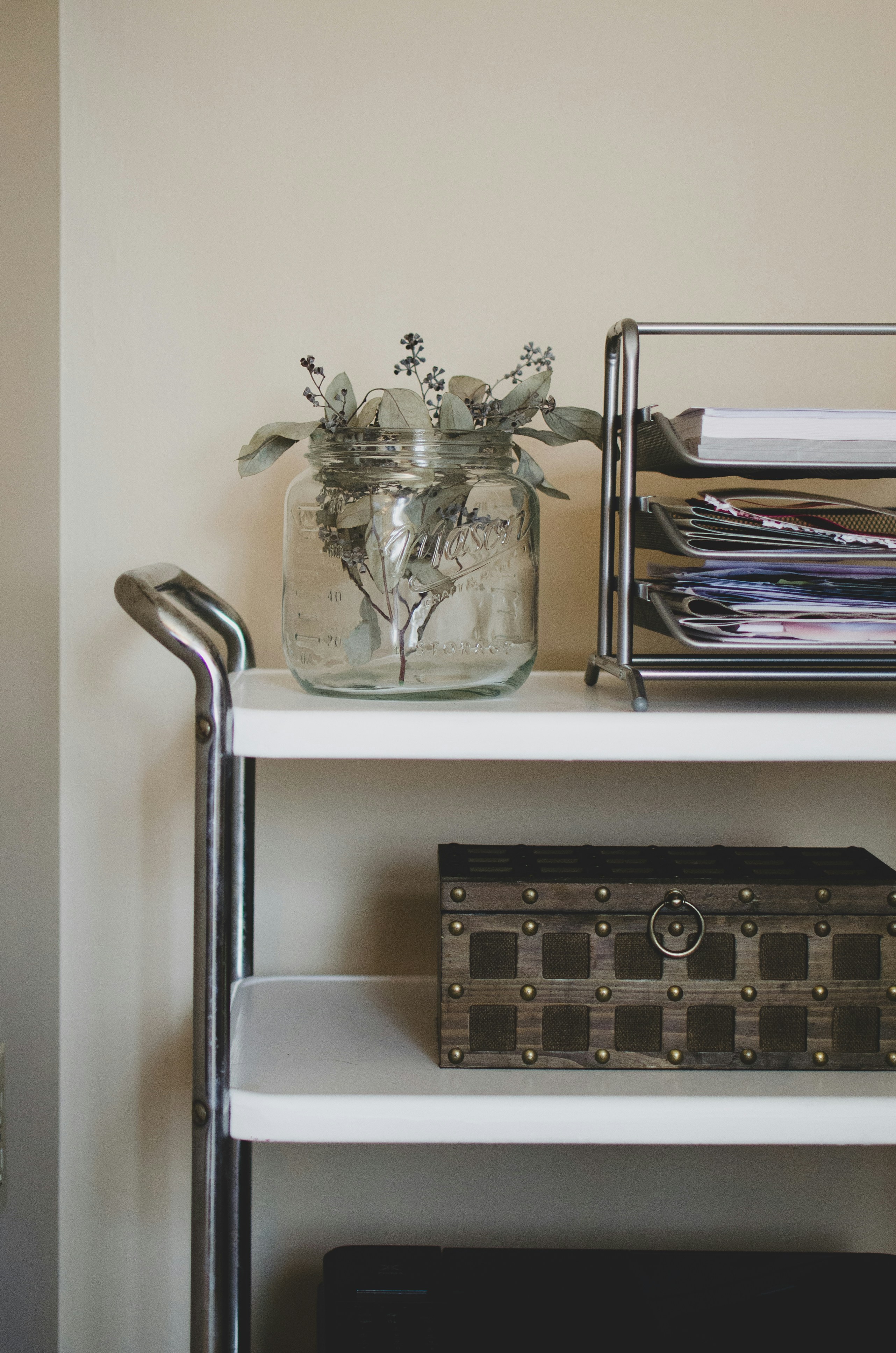 clear glass vase on white wooden shelf