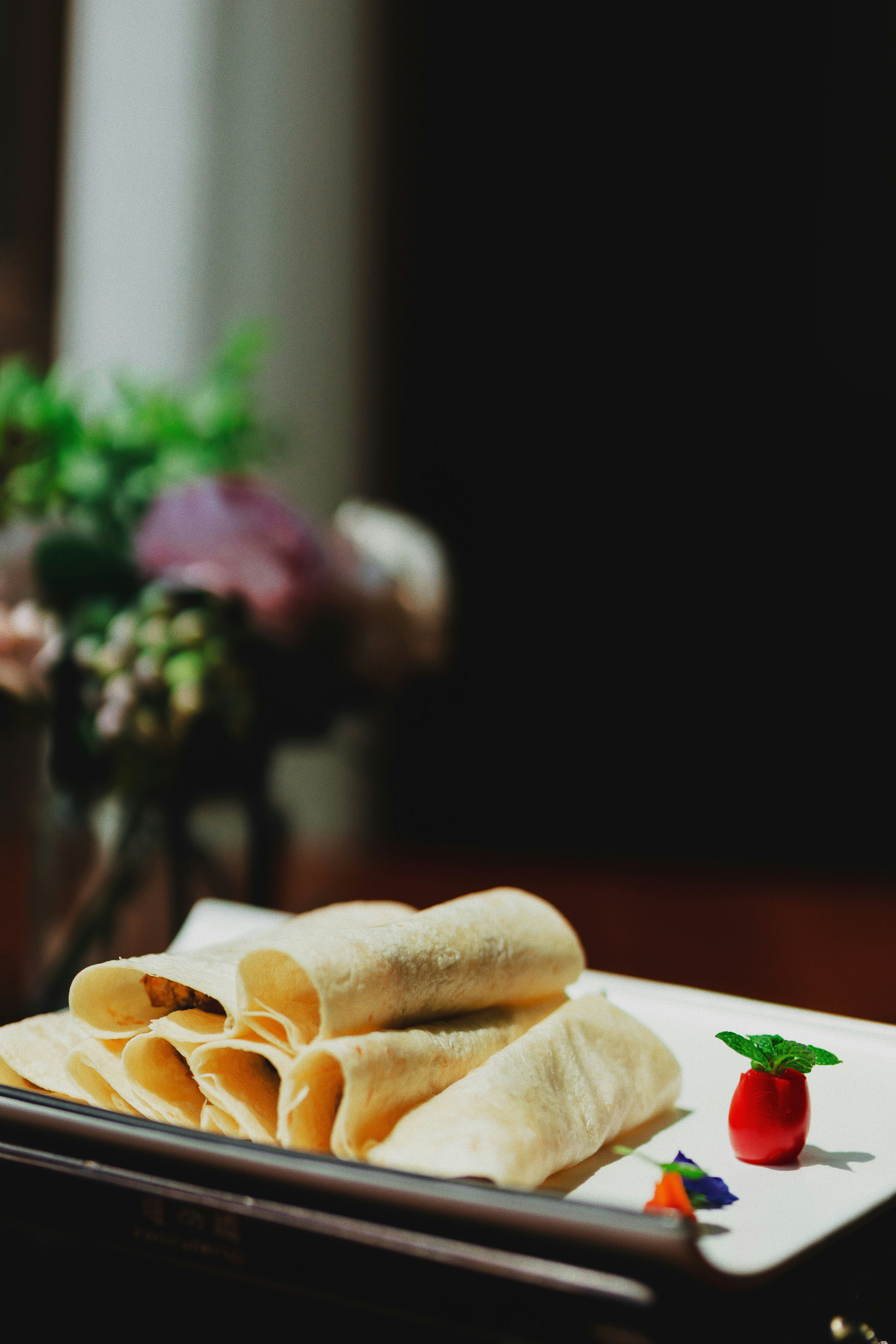 Delicate Crepes on a White Platter with a Ruby Rose