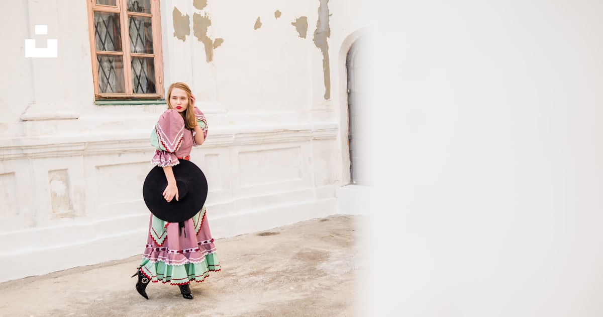Foto Mujer Con Vestido Negro Y Rojo Parada Cerca De Una Pared Blanca