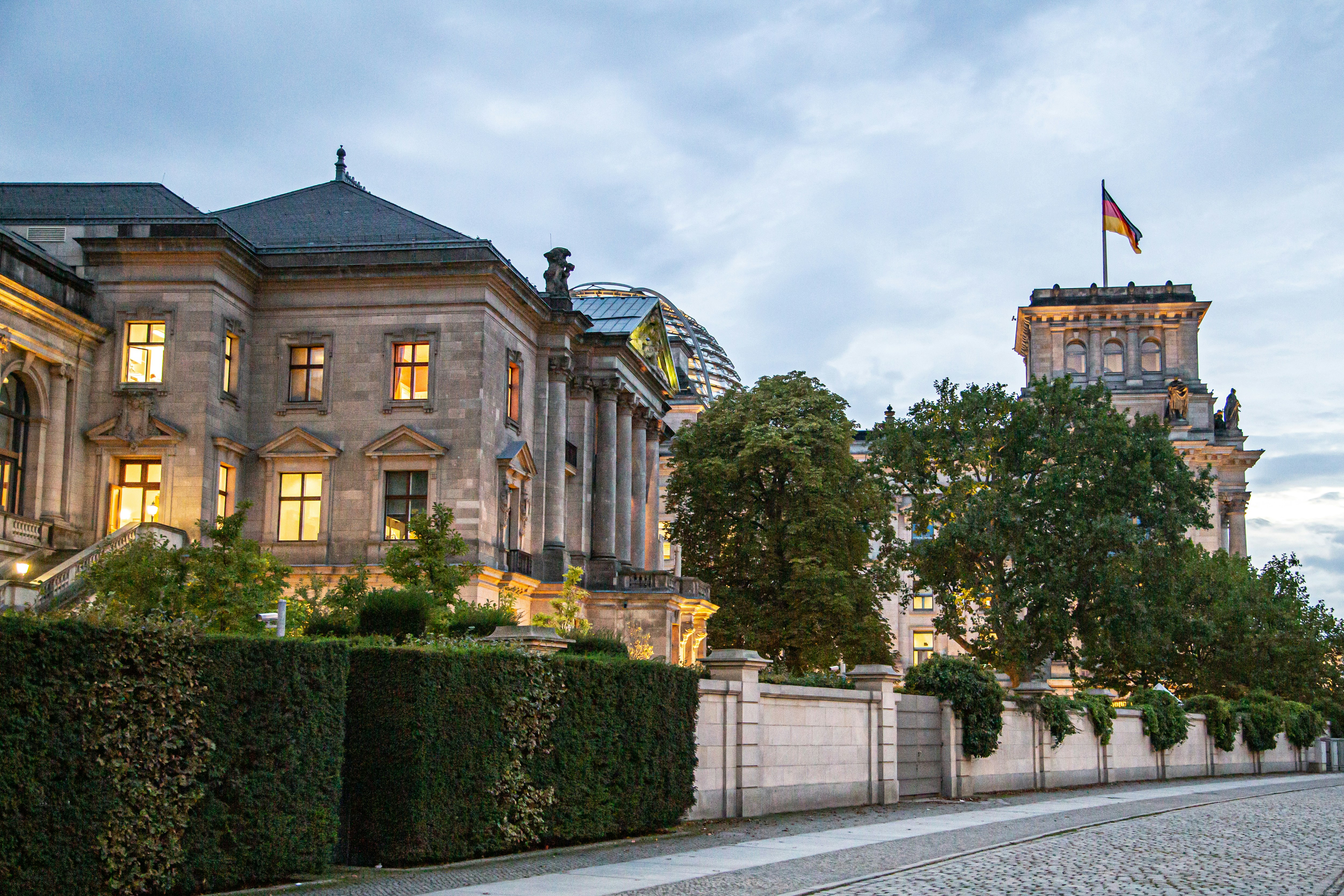 Sunlit Facade of a Historic Government Building with a German Flag