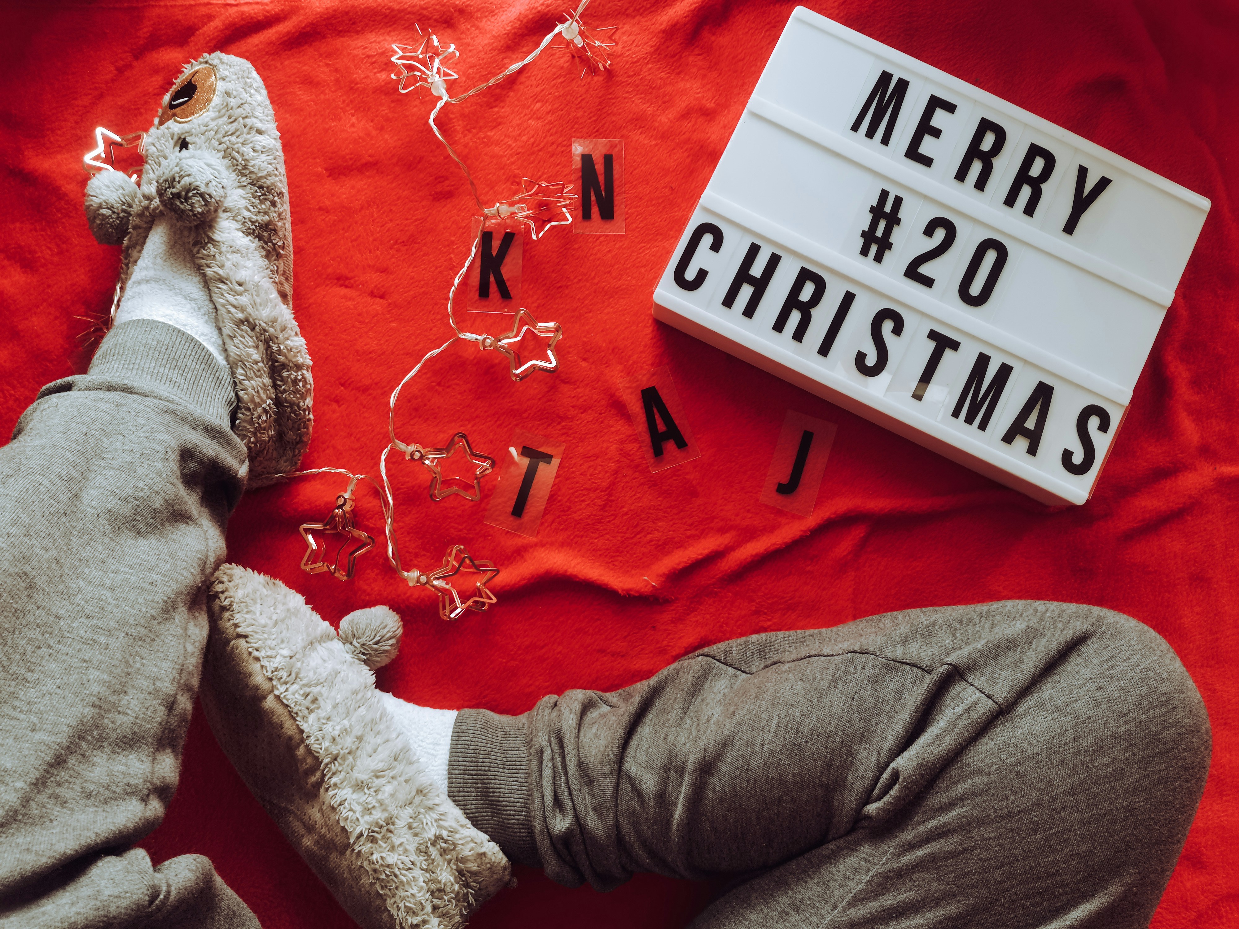 Crimson Comfort: A Cozy Christmas Moment Framed by a Lit Message