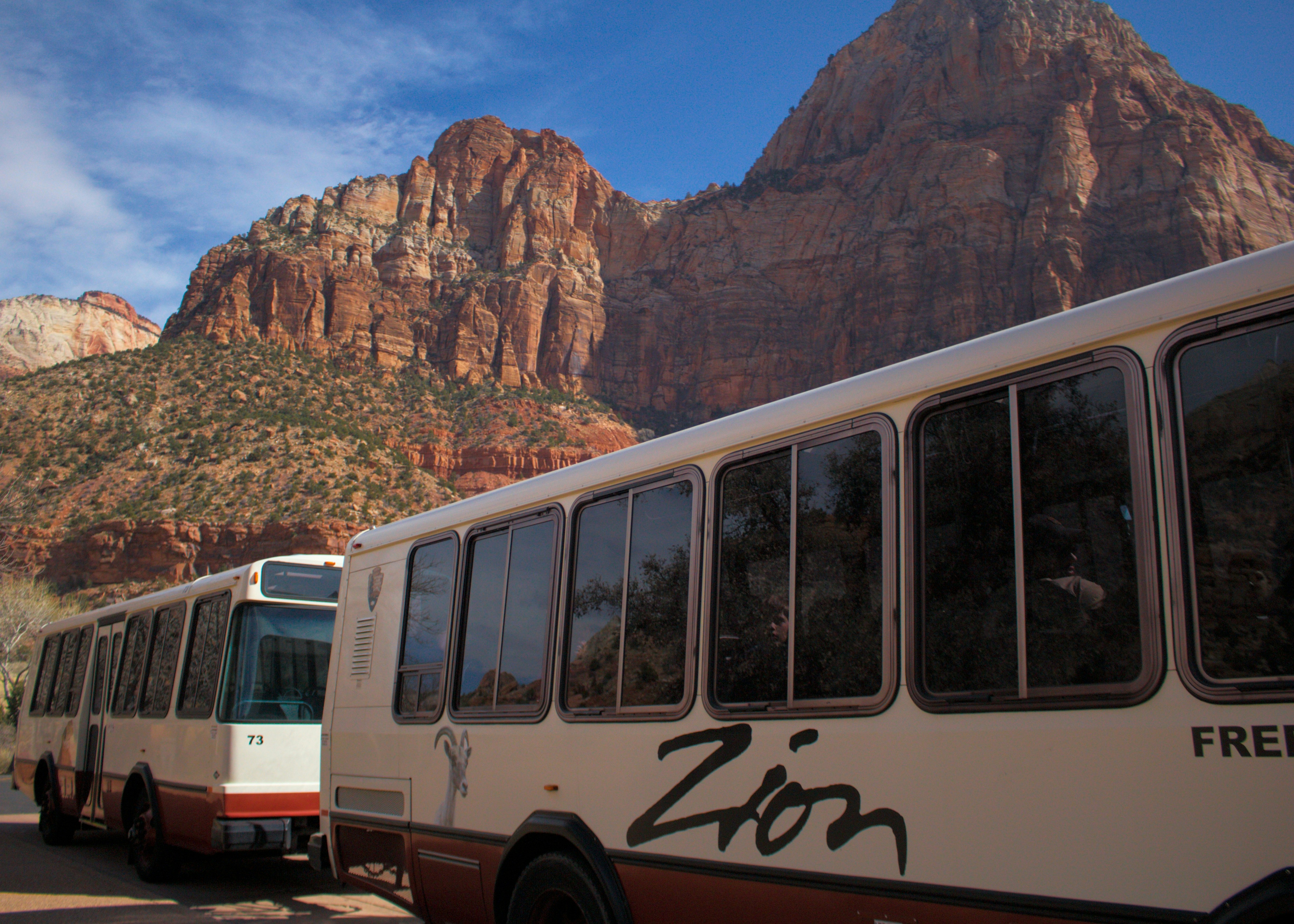 Desert Bus Rendezvous Beneath Red Rock Formations