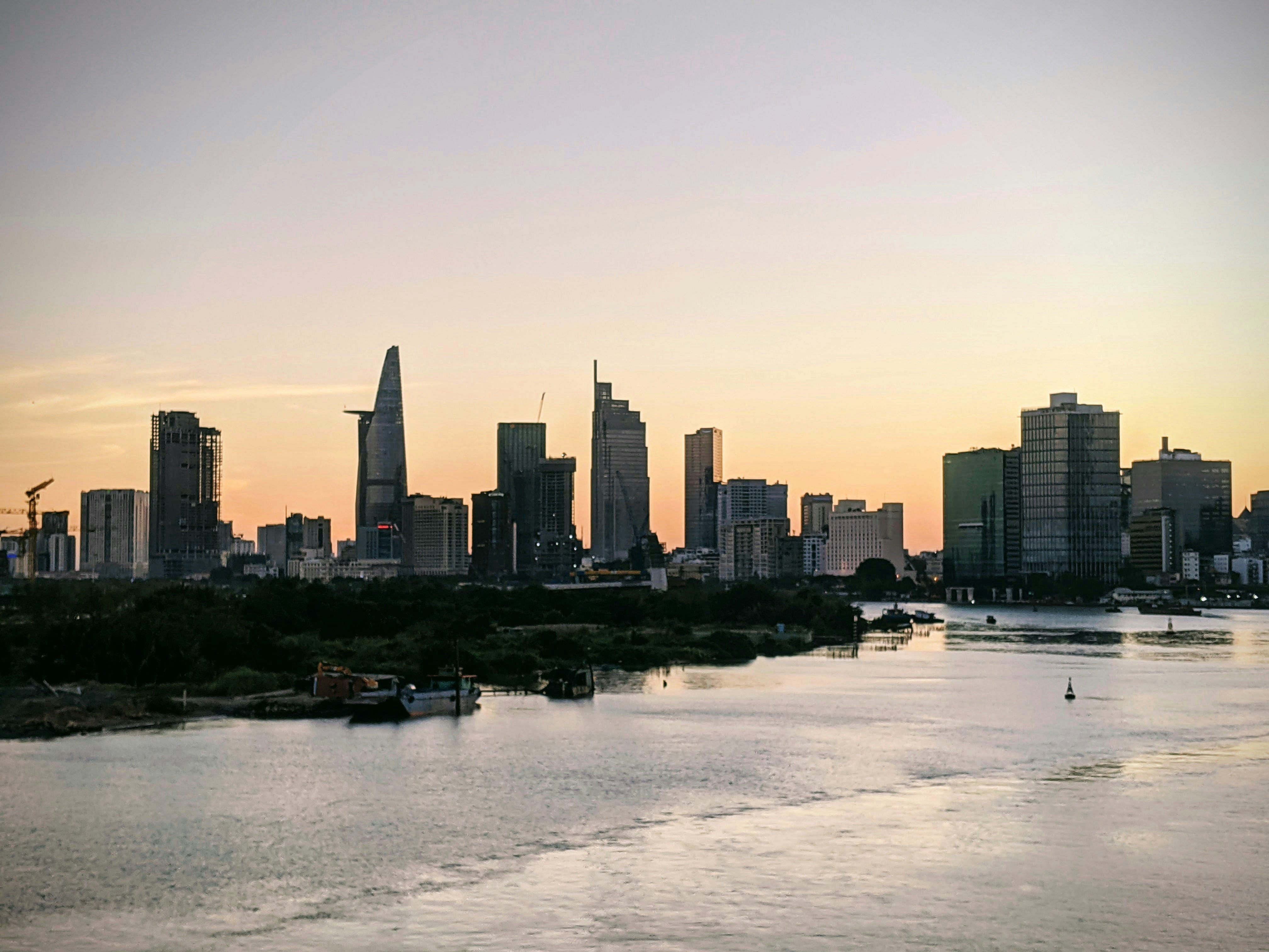 City skyline at dusk with buildings silhouetted against a pastel sky.