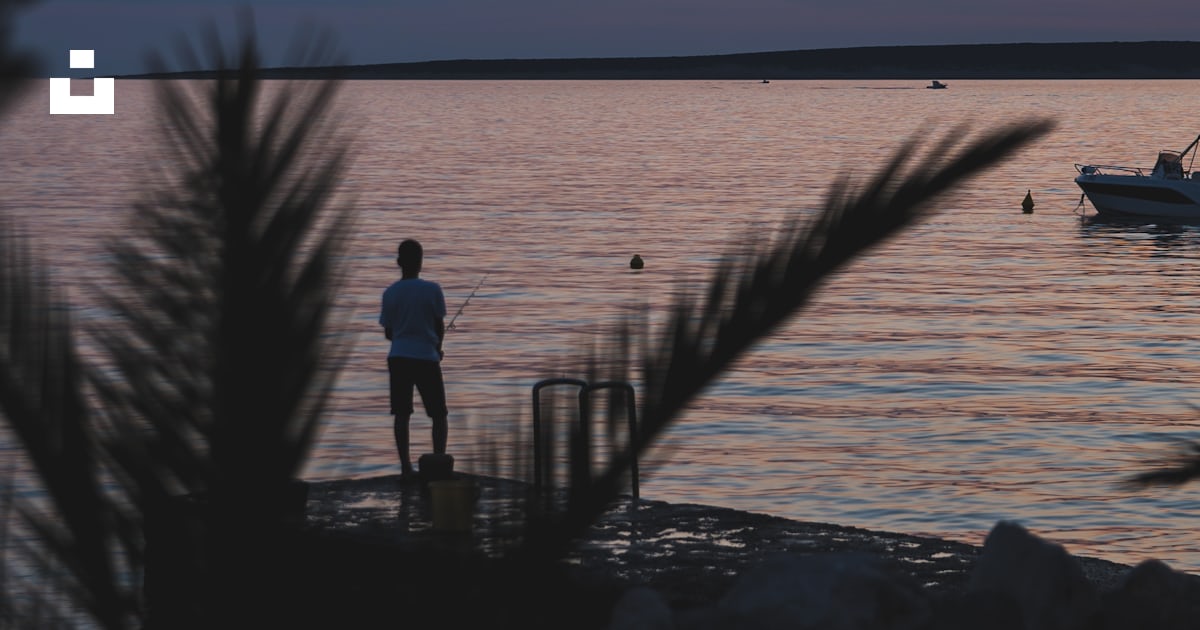 Foto Silueta De Hombre De Pie En El Muelle Durante La Puesta De Sol