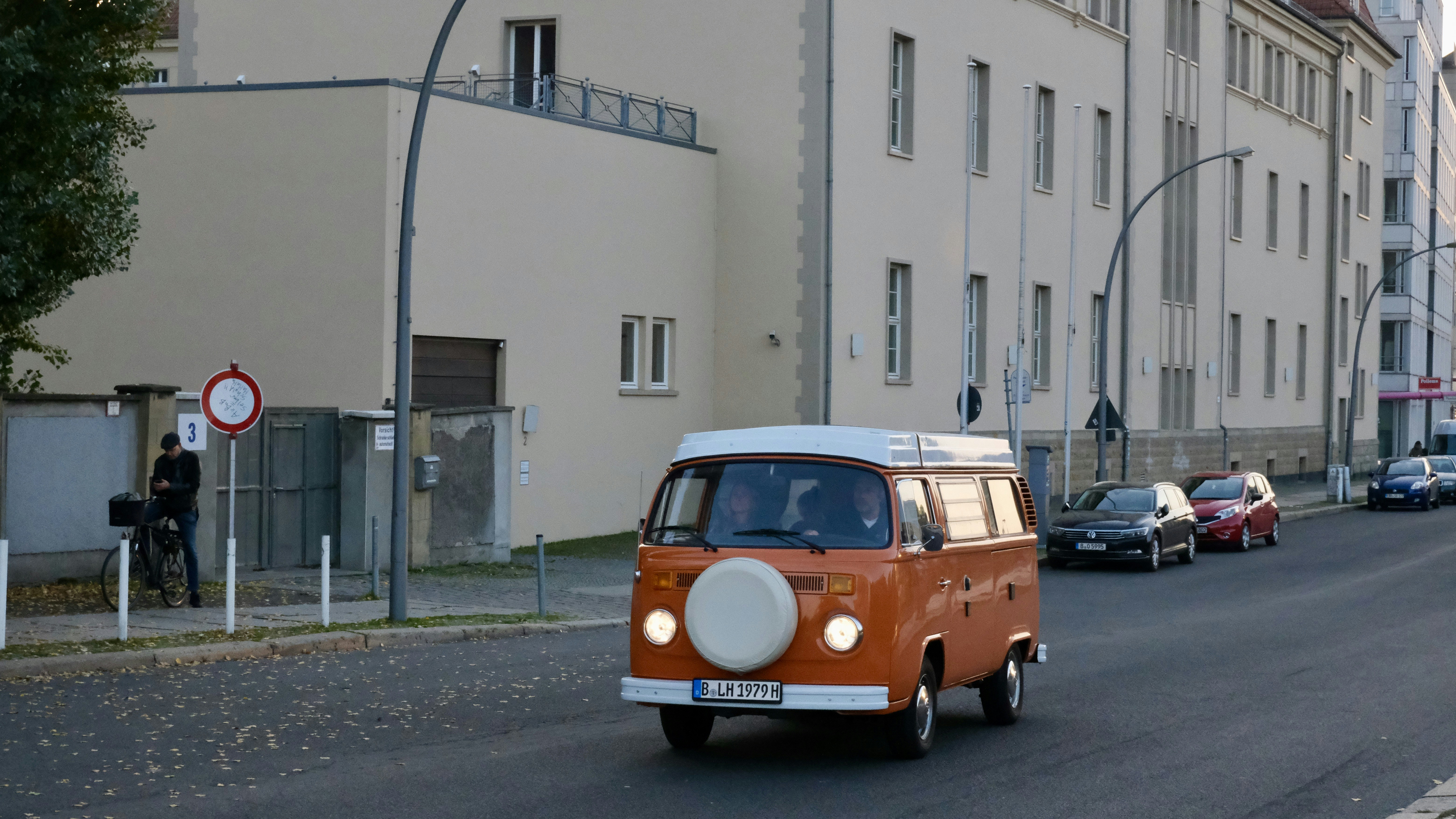 Orange VW Microbus Paces a Quiet European Street