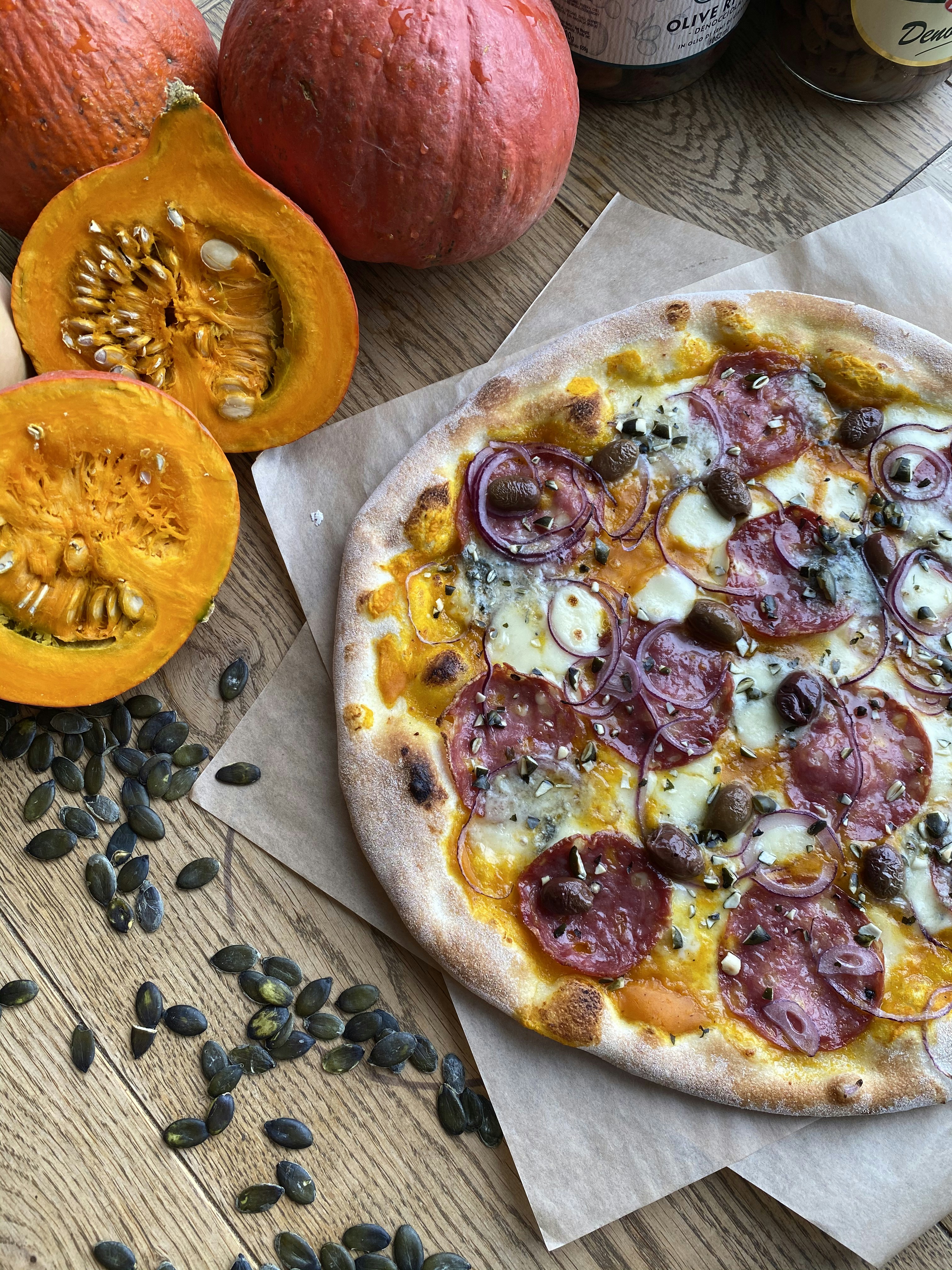 Pizza with pepperoni and black beans on brown wooden table photo – Free ...