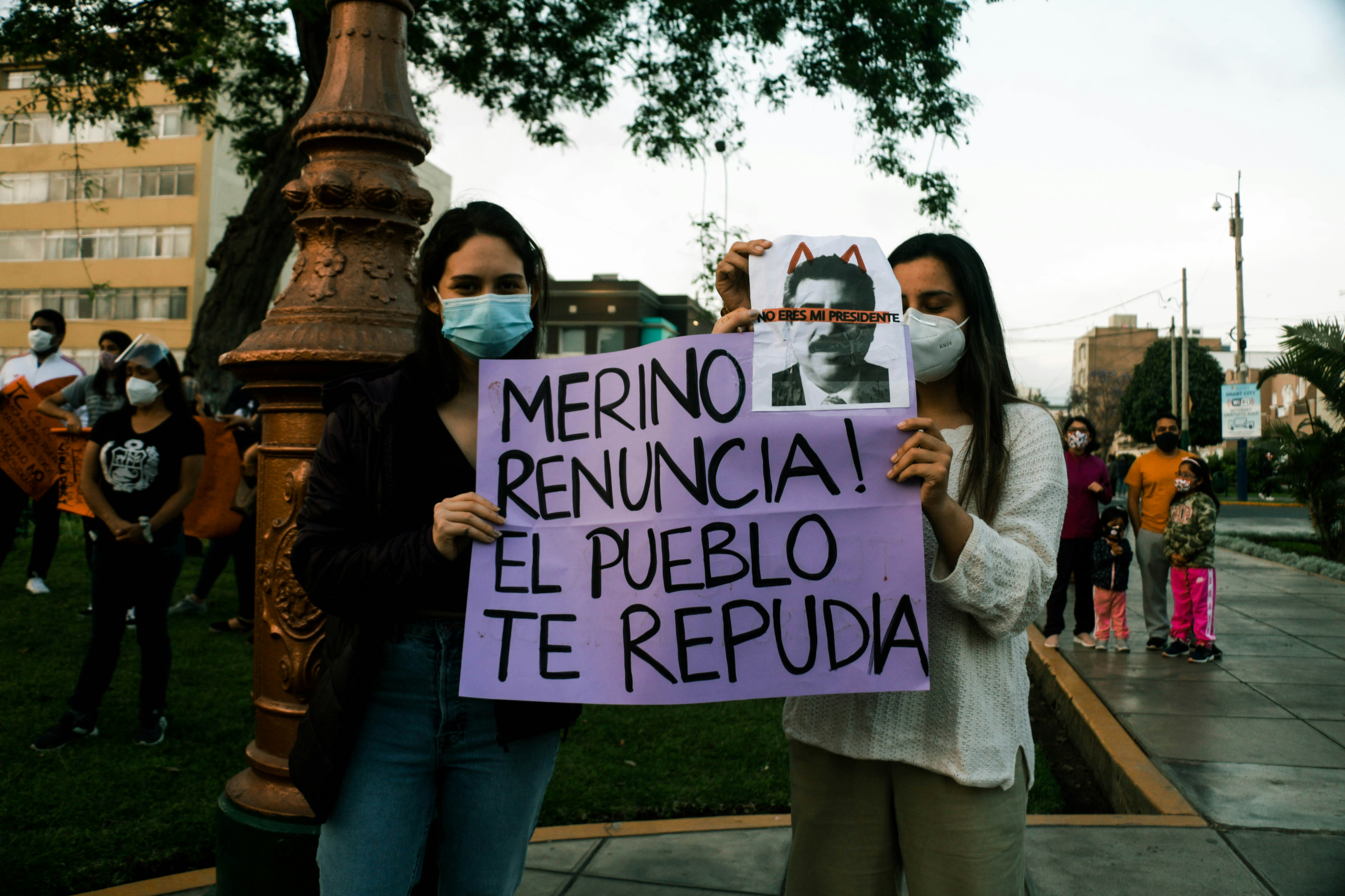 Foto Mujer con chaqueta negra sosteniendo letreros azules y blancos ...