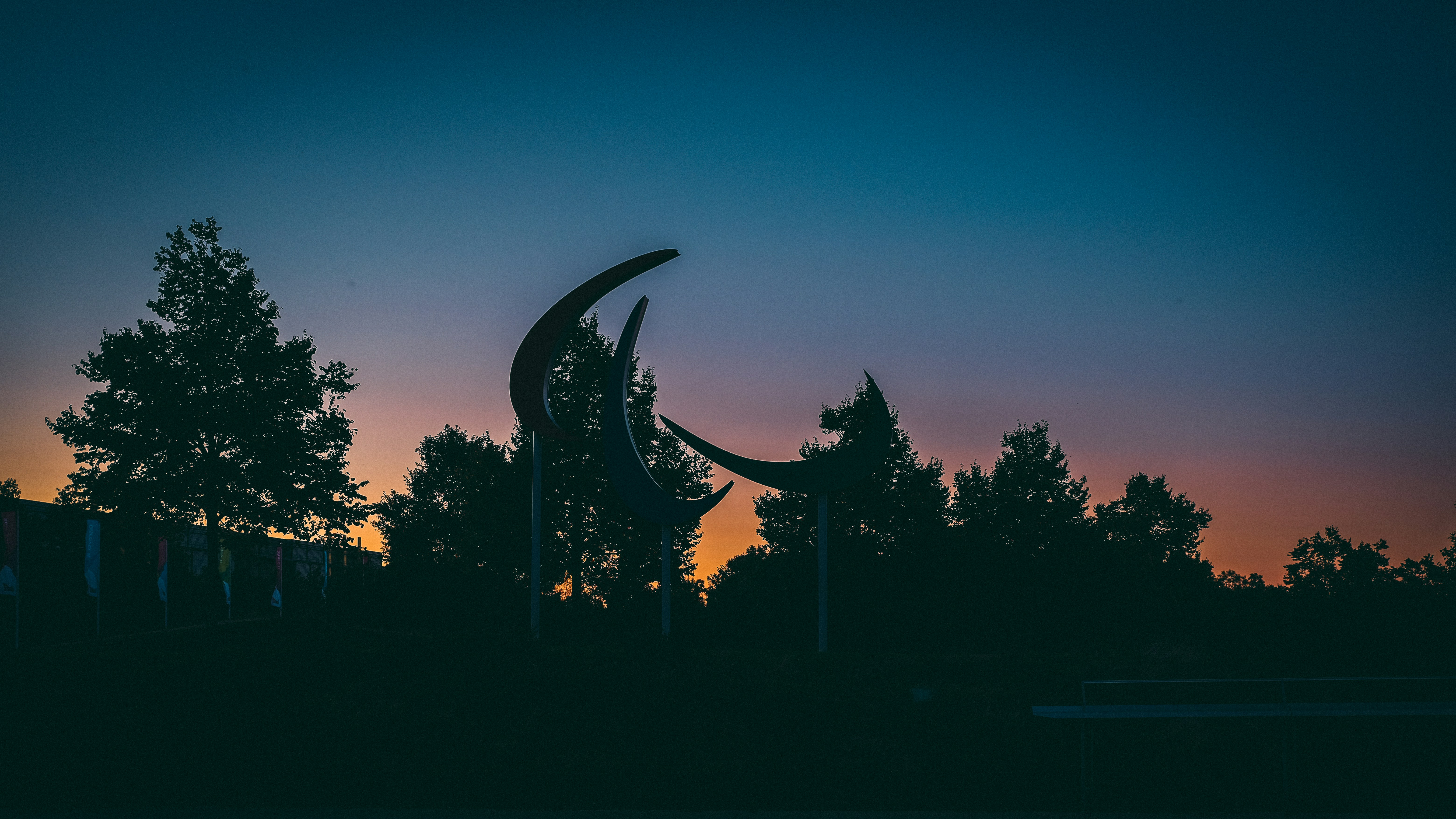 Twilight Silhouettes Behind Crescent Monuments