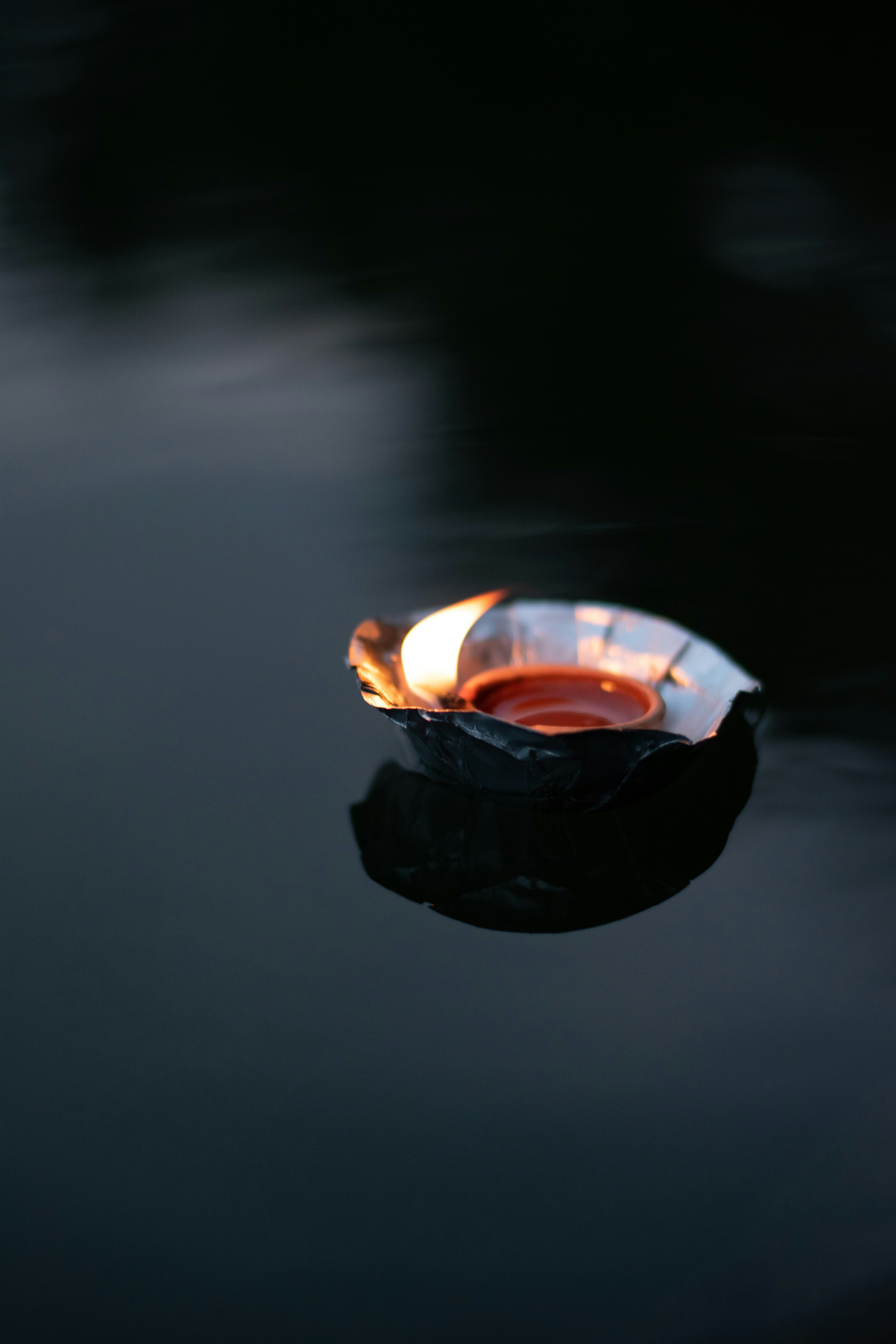 lighted candle in black round container