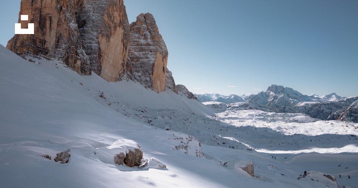 Montagne Rocheuse Brune Couverte De Neige Sous Un Ciel Bleu Pendant La