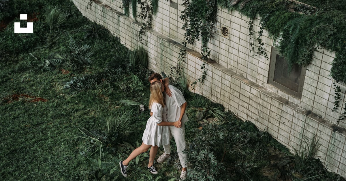 昼間、緑の芝生の上に立つ白いシャツと灰色のズボンを着た女性の写真 Unsplashの無料自然写真