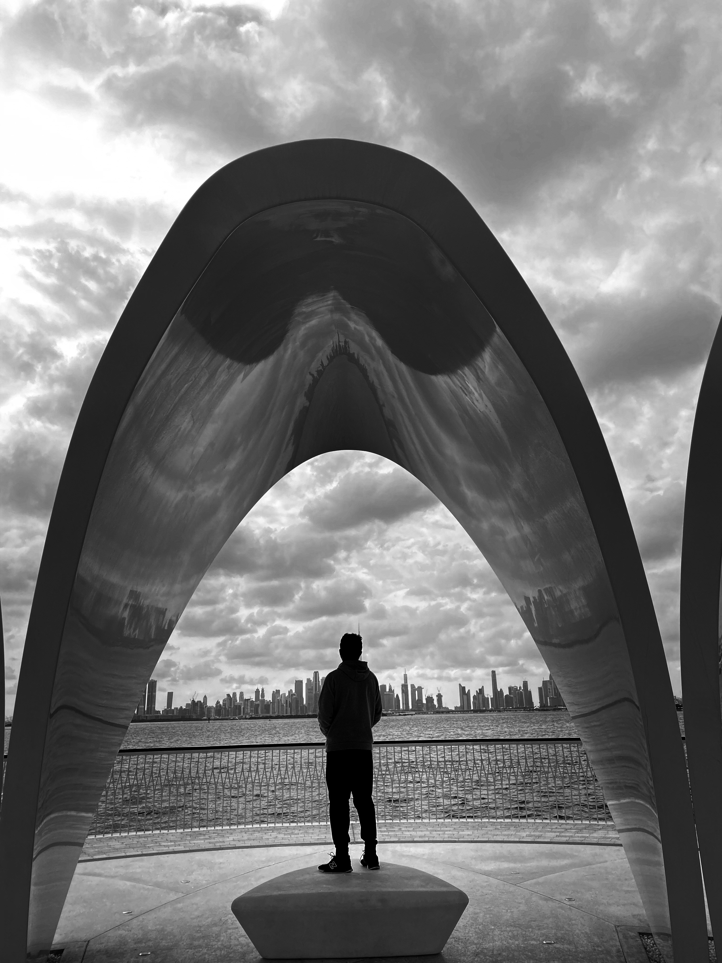 Silhouette Beneath the Arch: Cityscape Framed by Sculpture