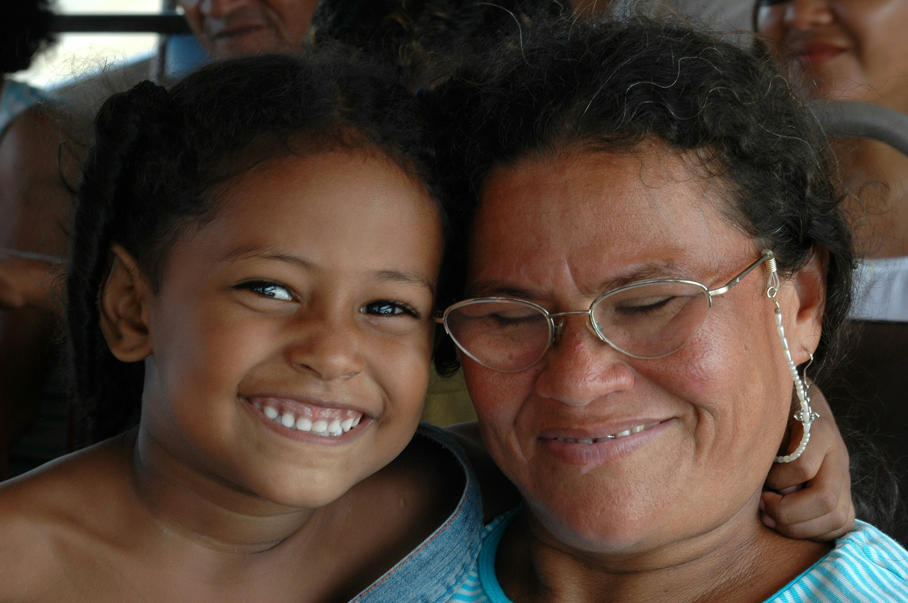 Child embraces an older woman with a joyful smile on a bus ride.