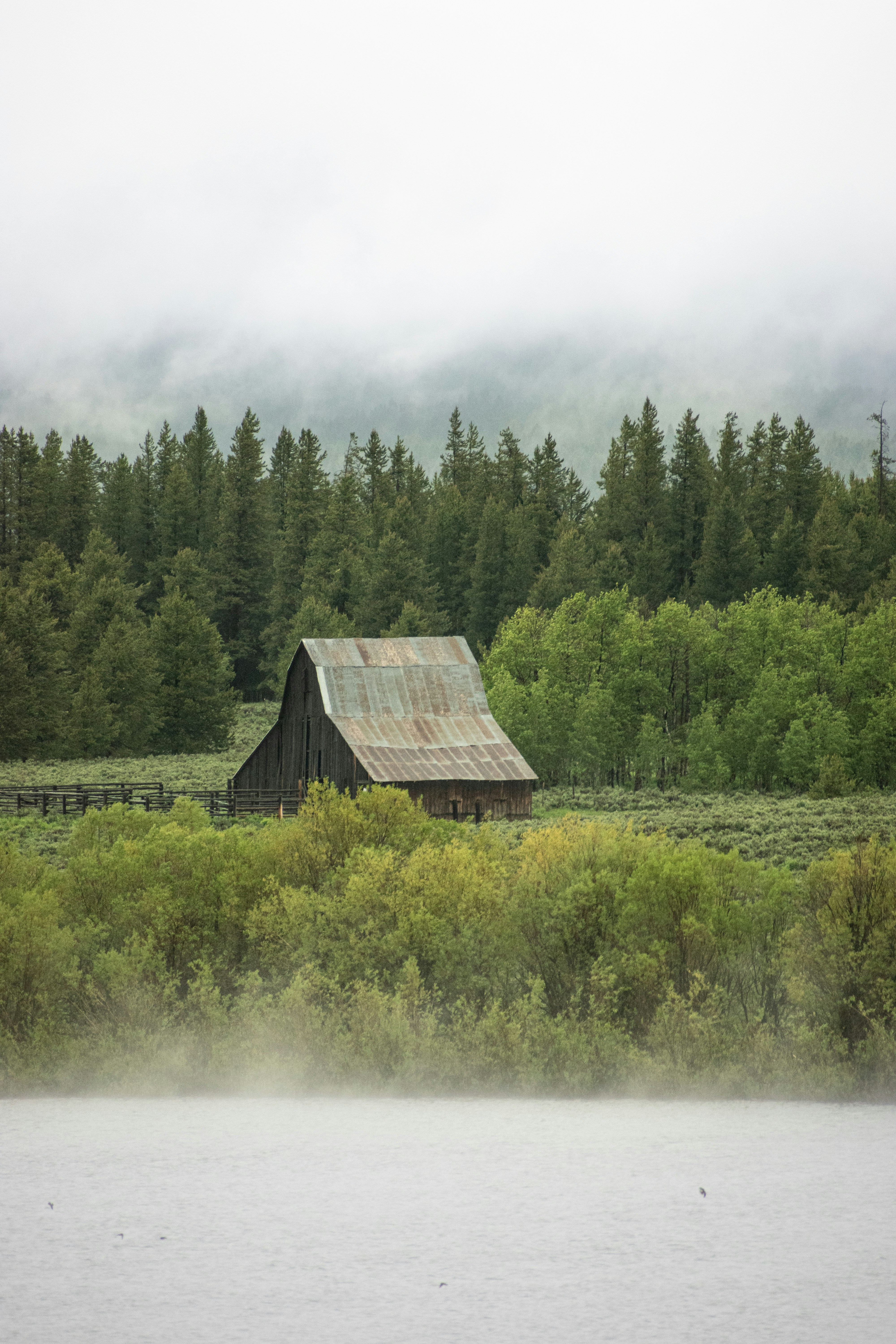 Rust-Trimmed Barn Against a Mist-Wrapped Valley