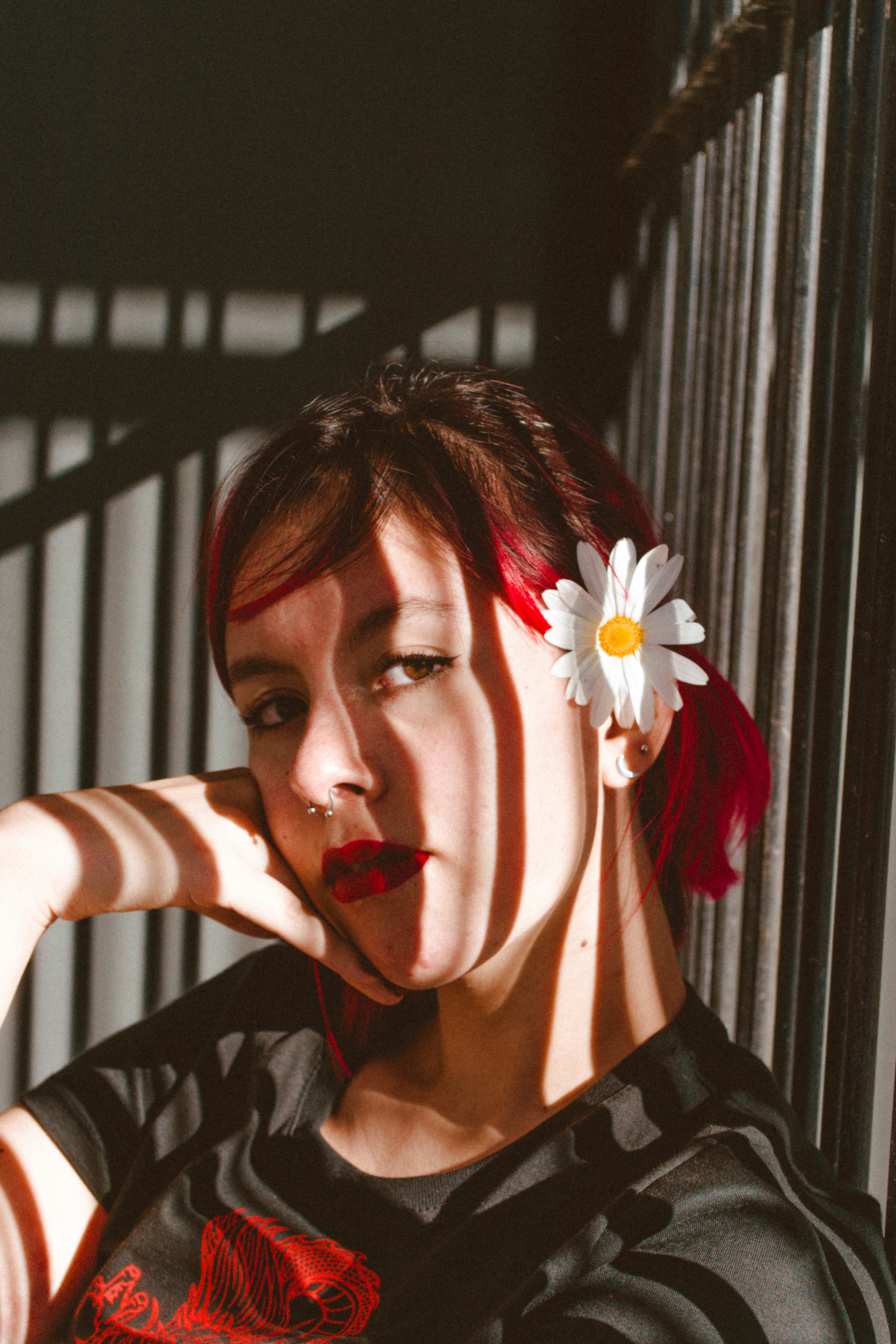 woman in black shirt with white flower on her ear