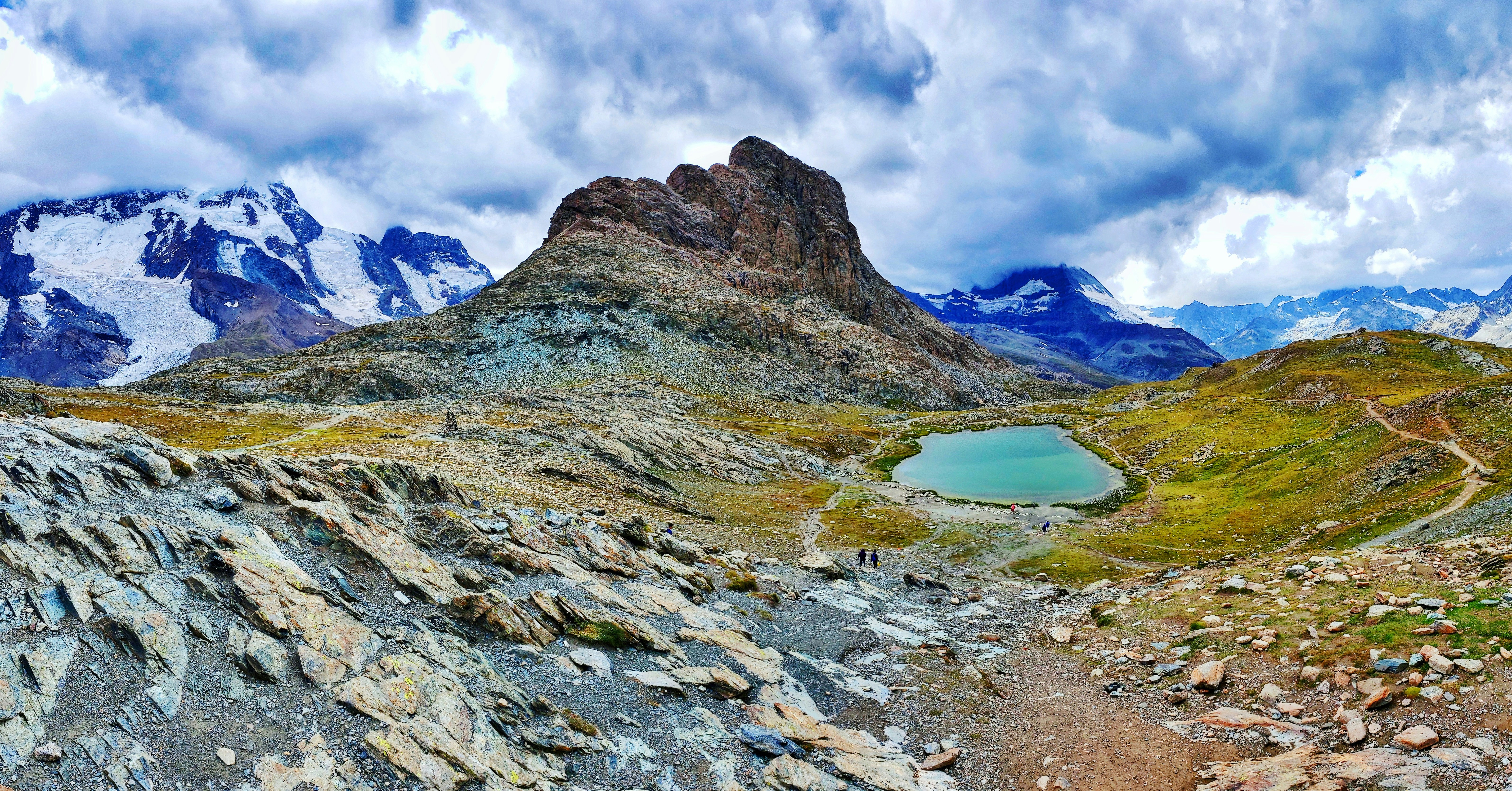 Lago azul en medio de las montañas rocosas bajo las nubes blancas y el ...