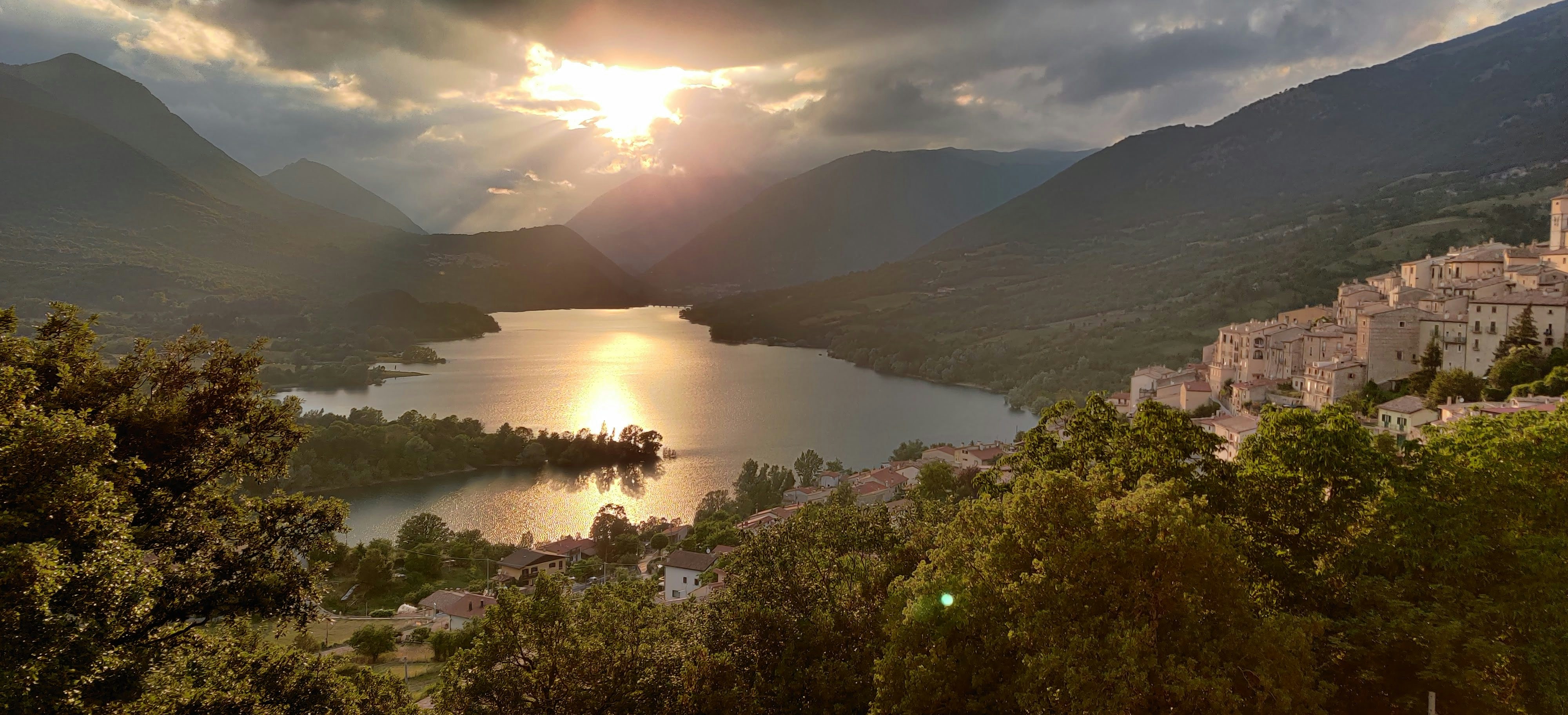 Dusk Over the Lake: Golden Reflections and a Cliffside Village
