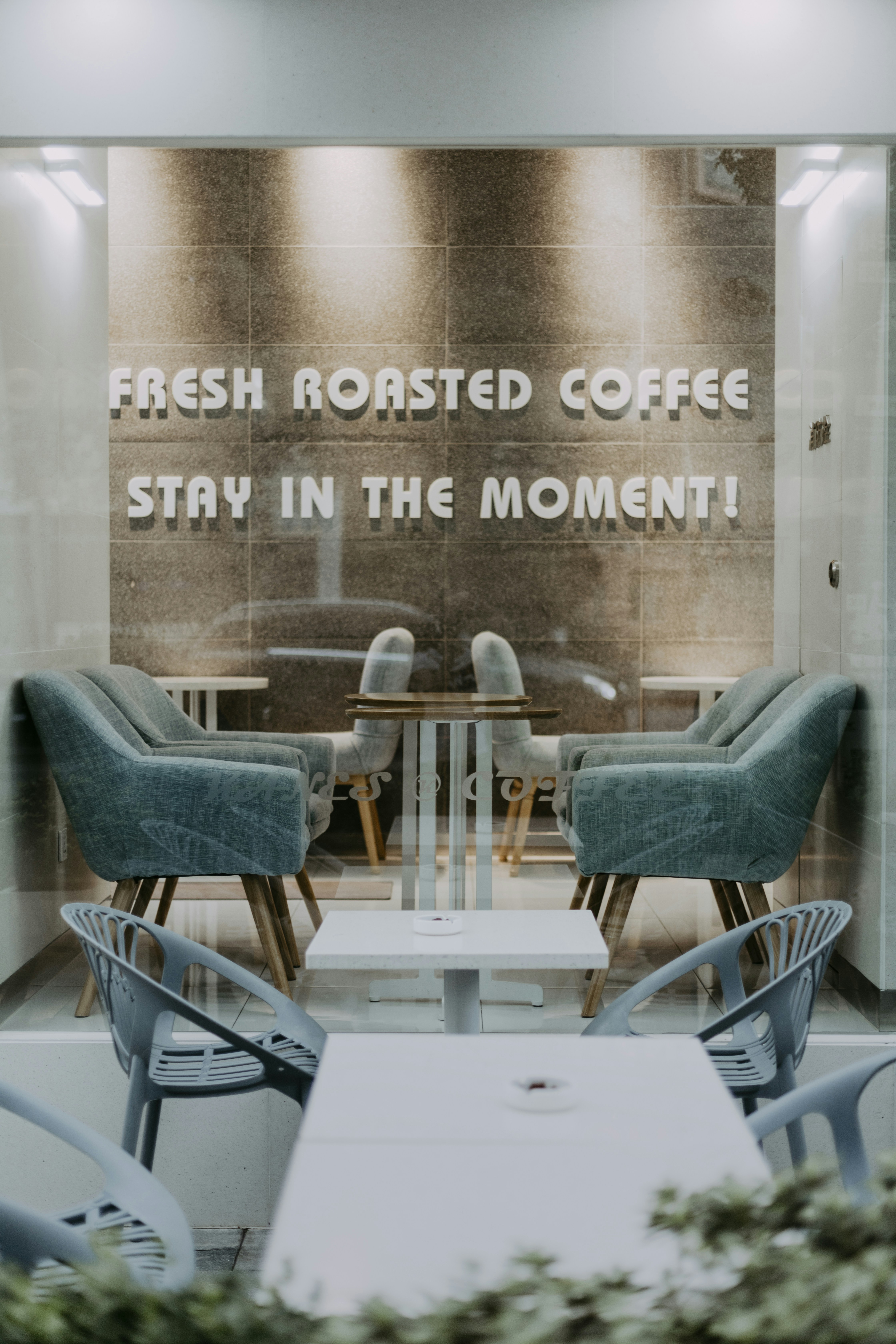 Through Glass and Teal: A Quiet Café Moment with Fresh Roasted Coffee Sign